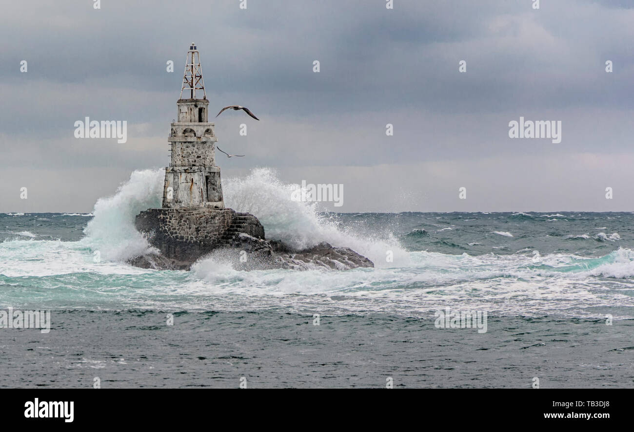 Lighthouse in the port of Ahtopol, Black Sea, Bulgaria.Large waves ...