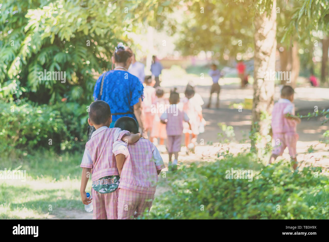 Kindergarten boy walk after female teacher and his friends back to ...