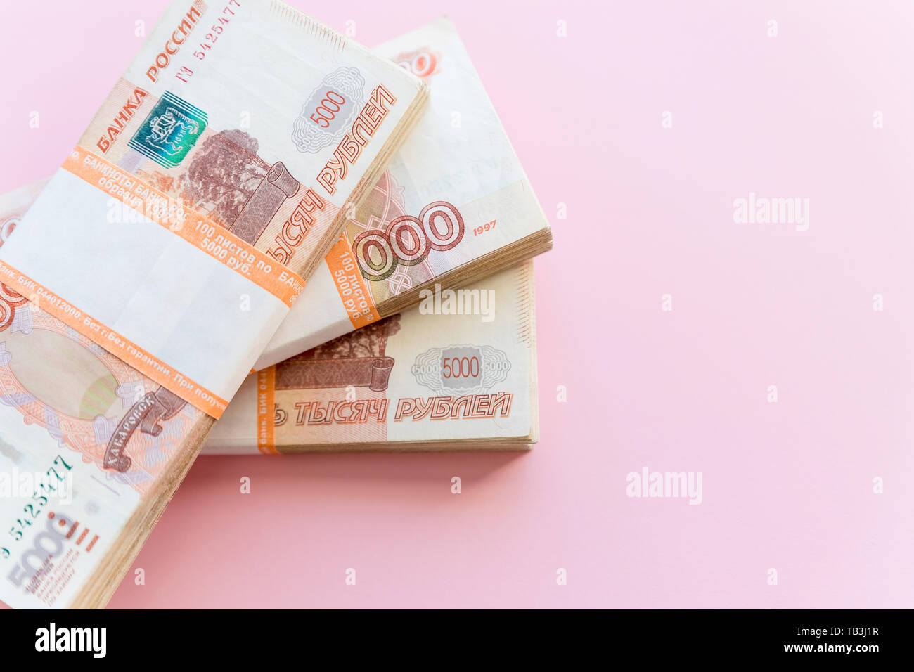 Stack of 5000 rubles packs isolated on pink. The concept of wealth ...