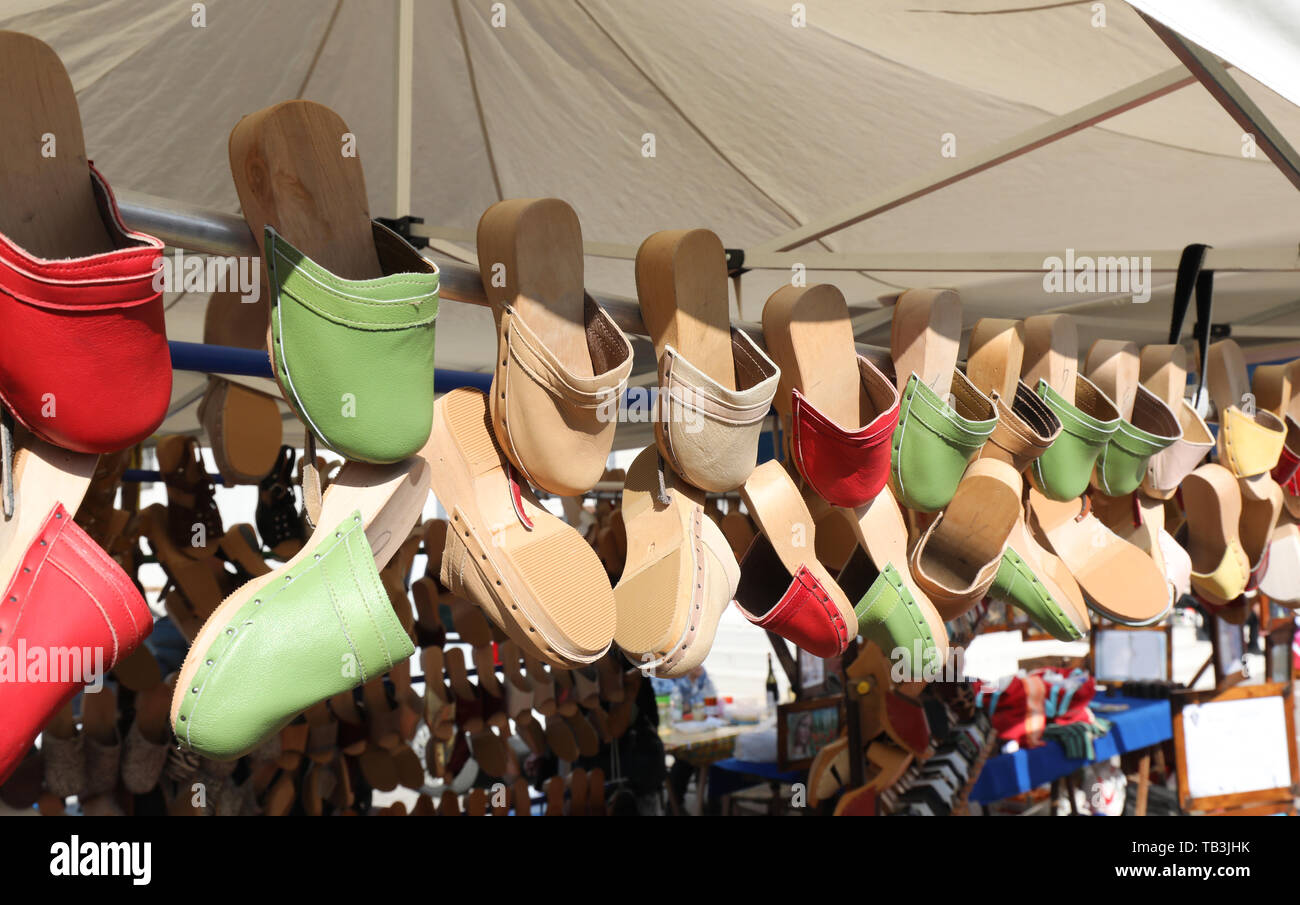 many handmade wooden clogs hanging from a market stall Stock Photo - Alamy