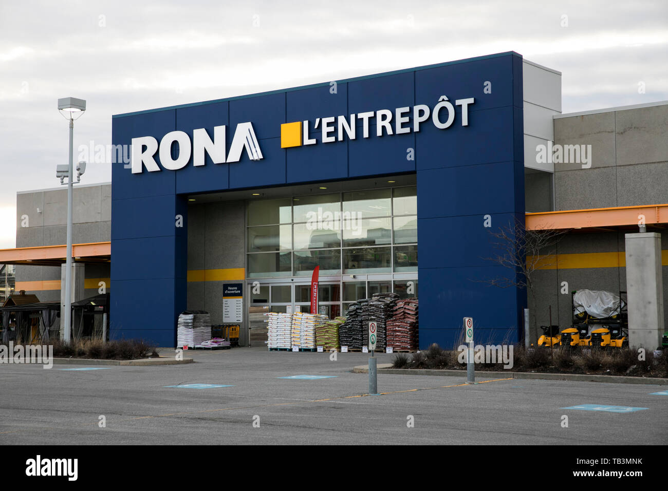 A logo sign outside of a Rona, Inc., retail store location in Brossard ...