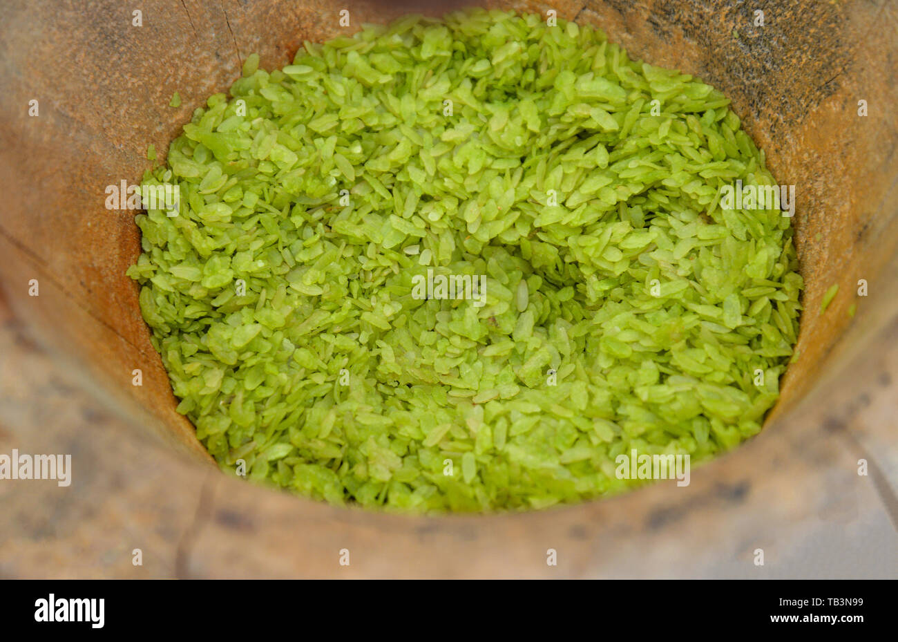 Rice green sweet pounded unripe rice flakes cereal in wooden mortar ...