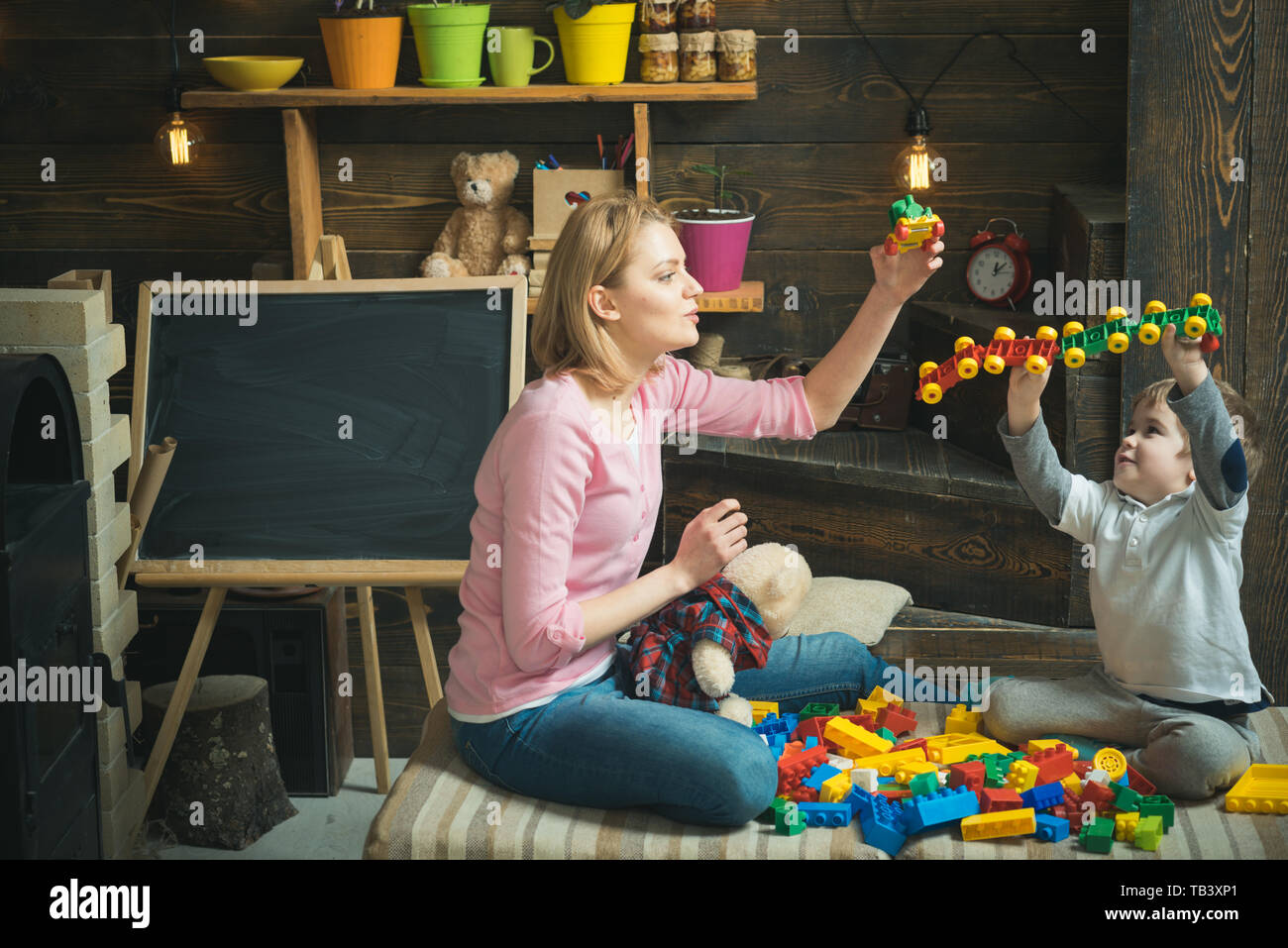 Friendship concept. Woman and little child play with plastic toys ...