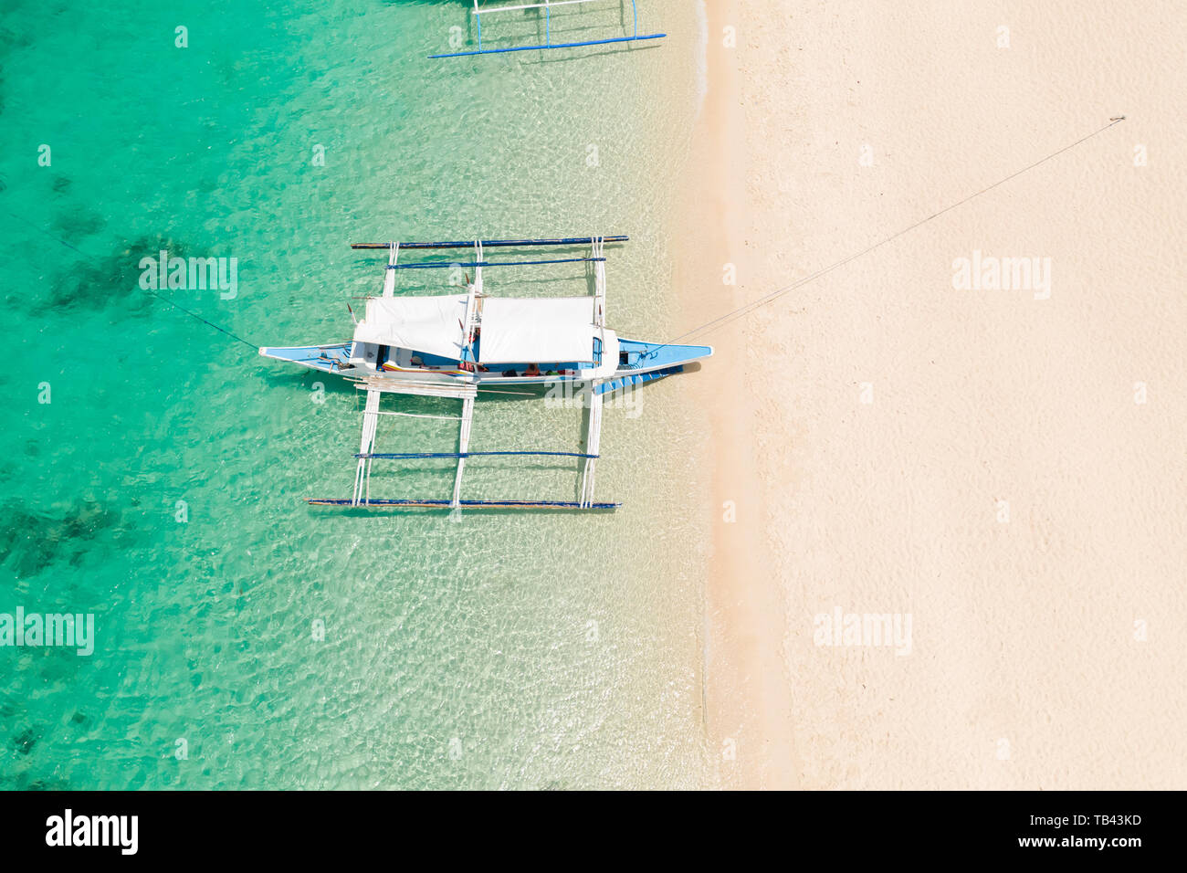 Traditional Philippine boat in the tropical lagoon. White sandy beach ...