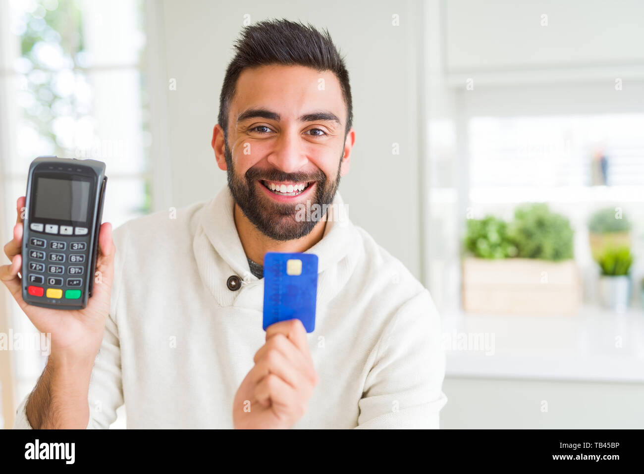 Business man smiling and holding point of sale terminal and credit card ...