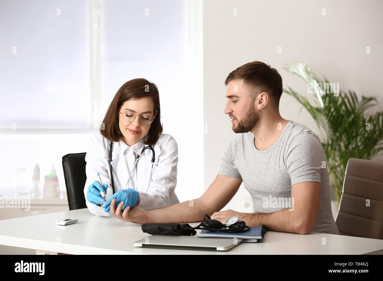 Doctor taking blood sample of diabetic patient in clinic Stock Photo ...