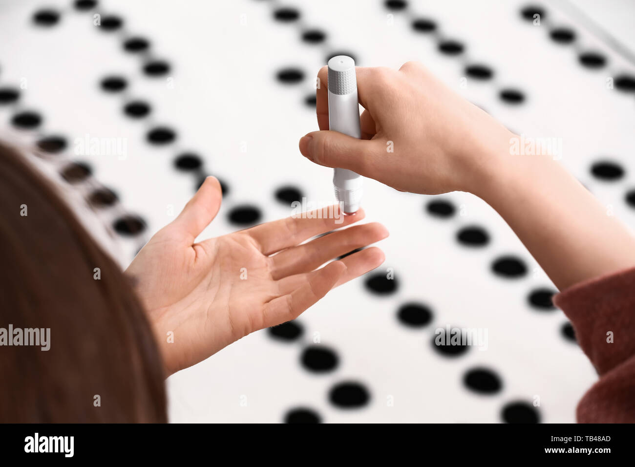 Diabetic woman taking blood sample with lancet pen at home Stock Photo ...