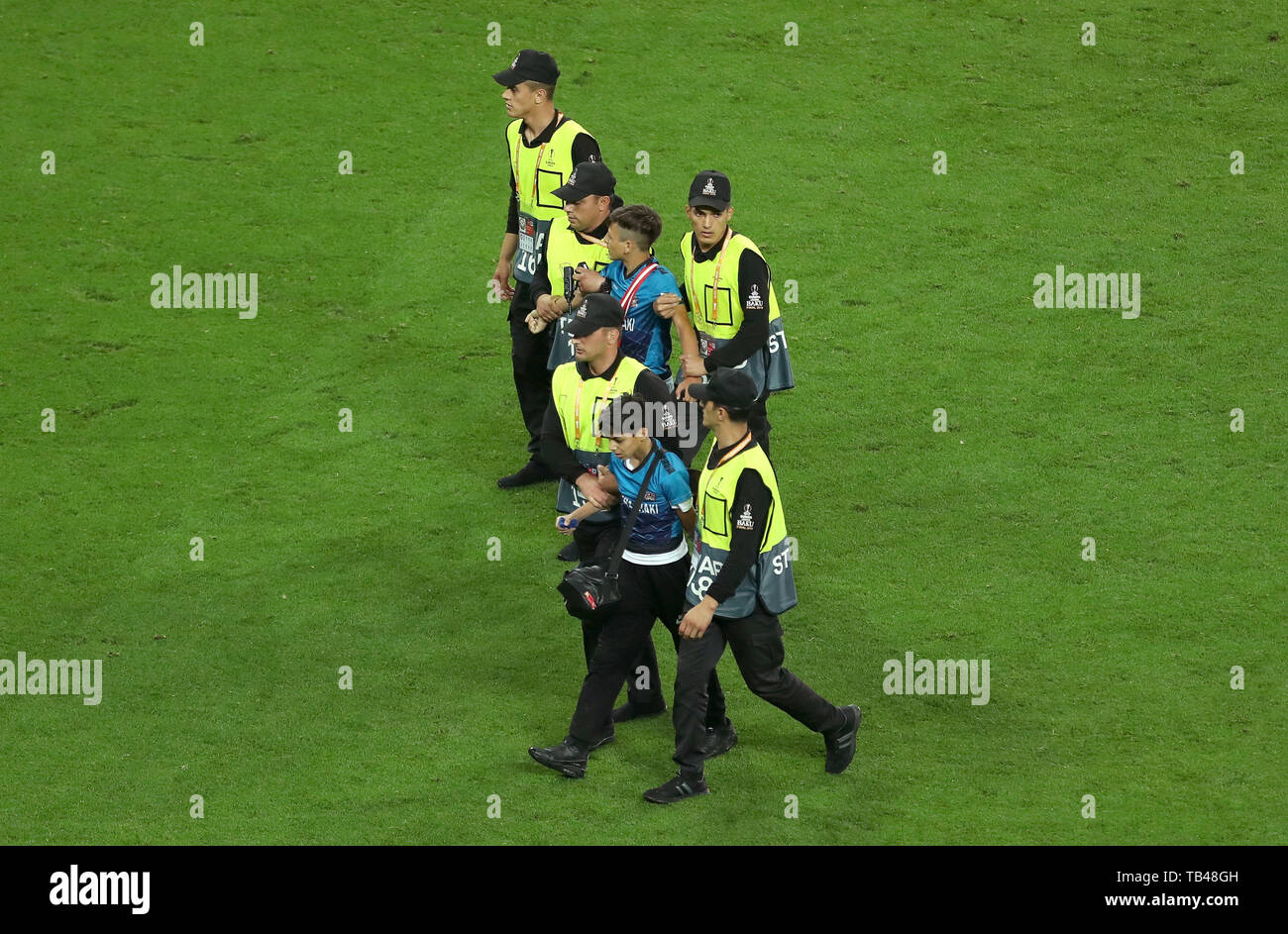 Two pitch invaders are escorted off the pitch after the game during the ...