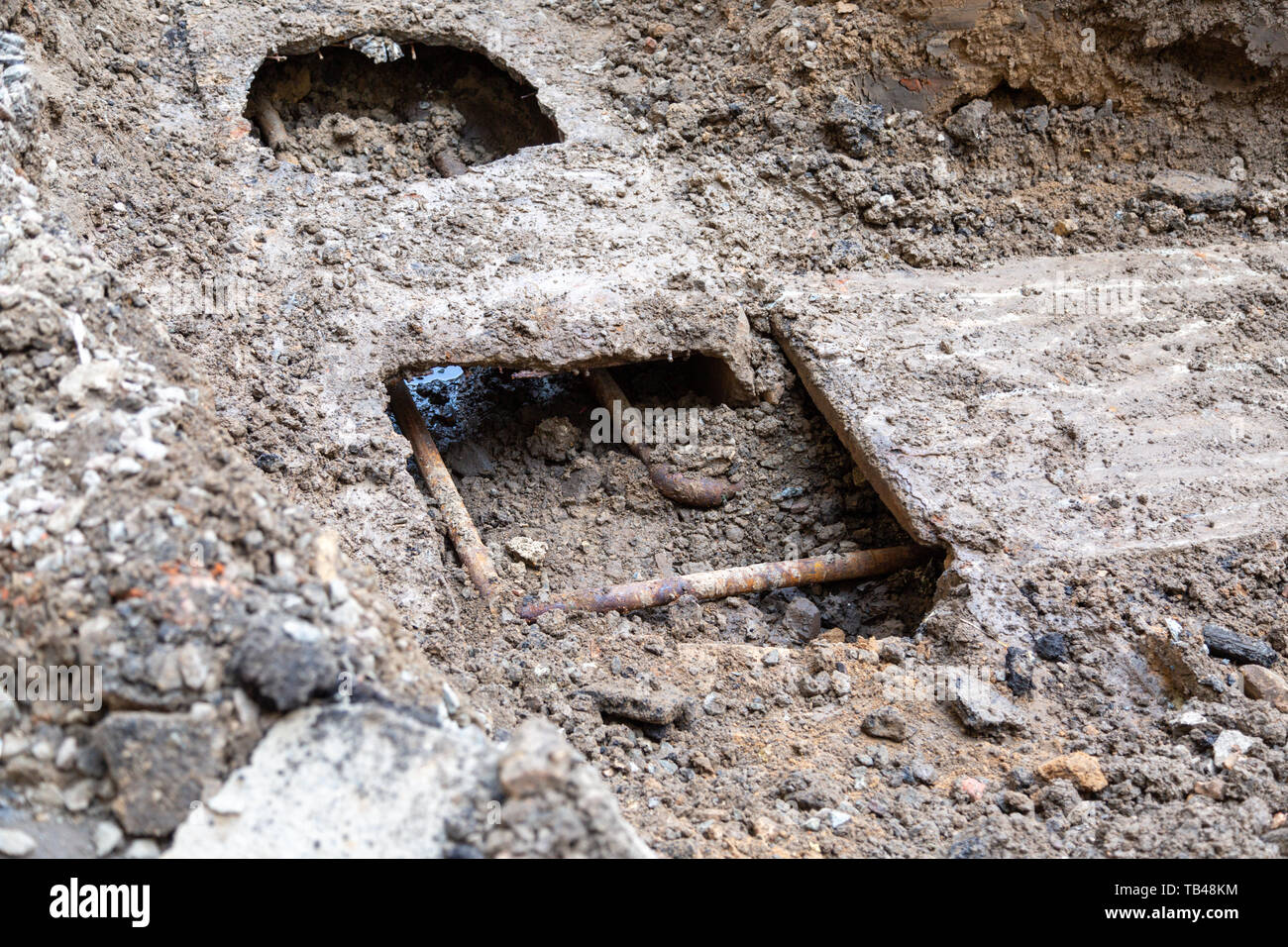 Old rusted water pipes in a concrete gutter. Repair work Stock Photo ...