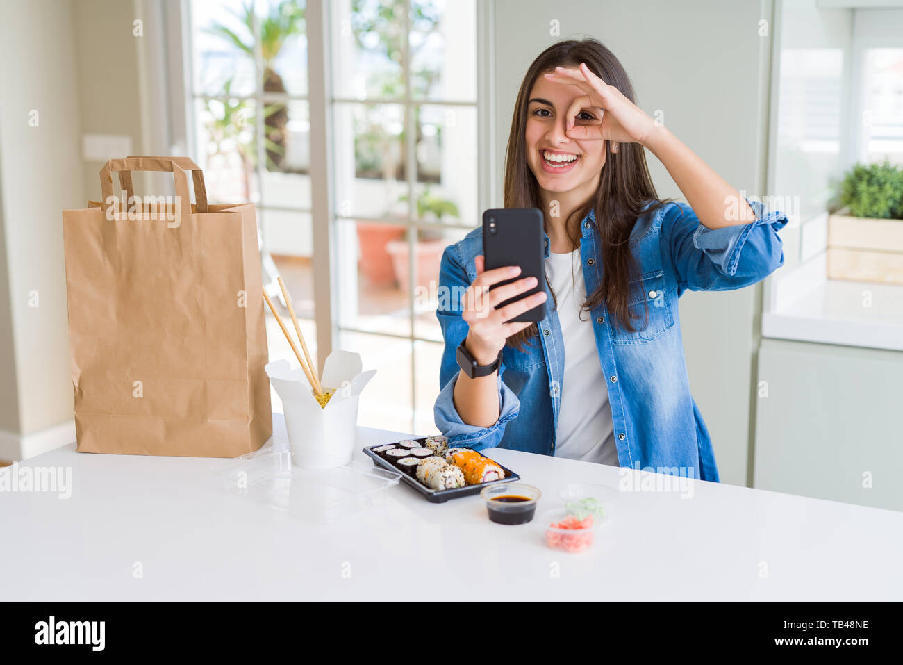 Beautiful young woman ordering food delivery from app using smartphone ...