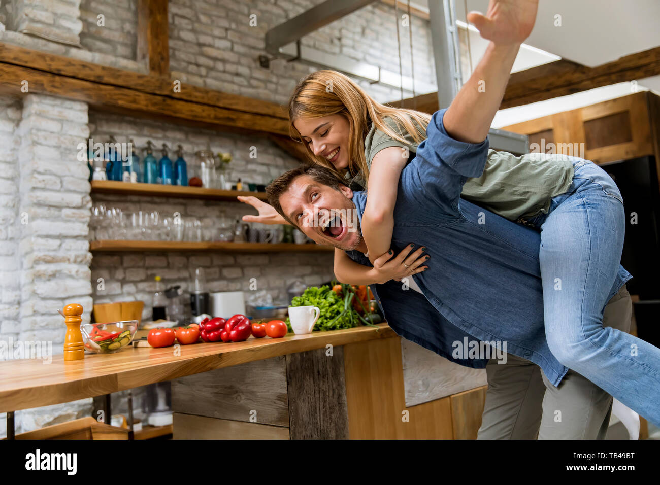Lovely young couple having fun together at rustic kitchen Stock Photo ...