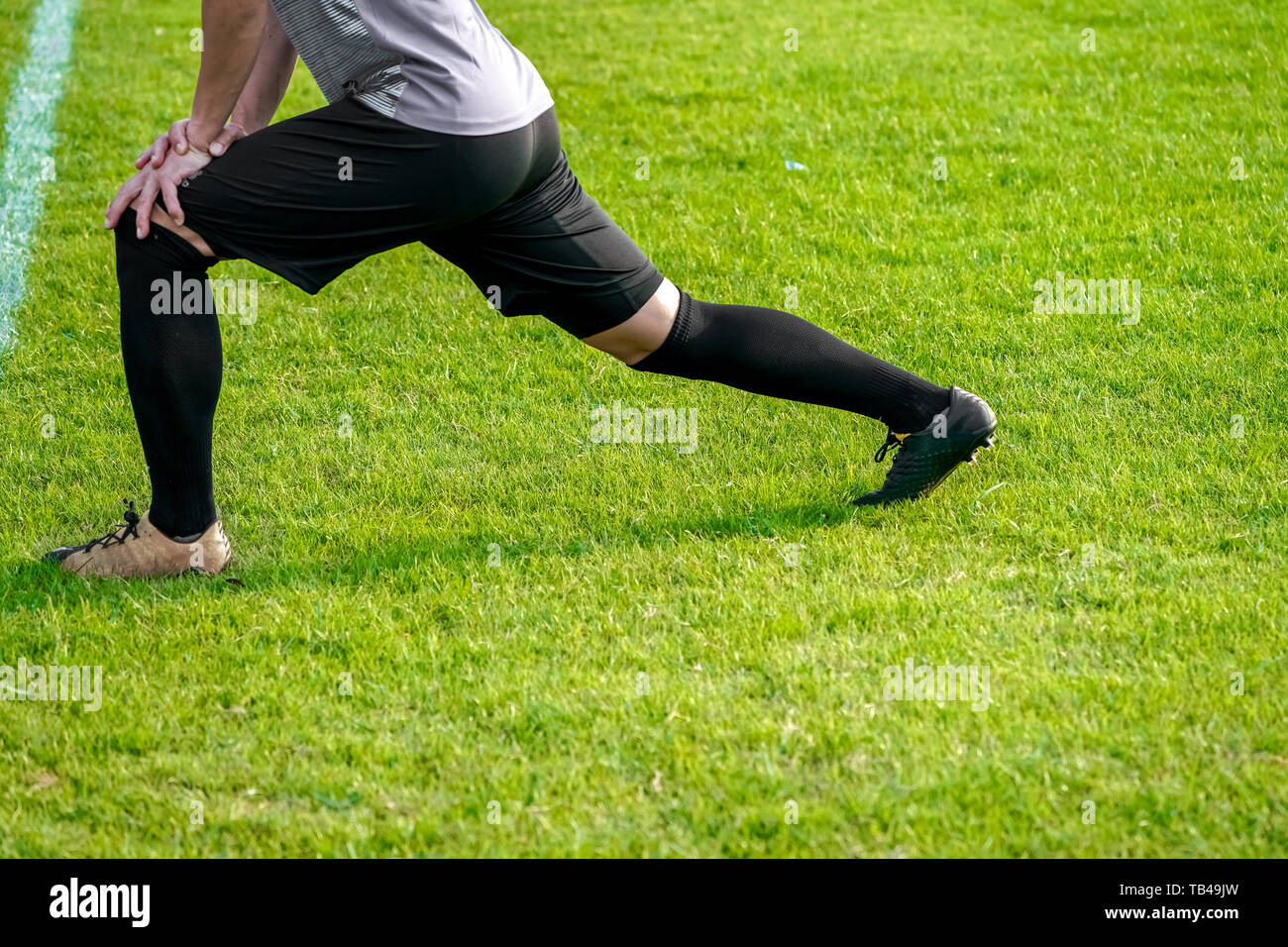 football player in the field was stretching, warming up for the game ...