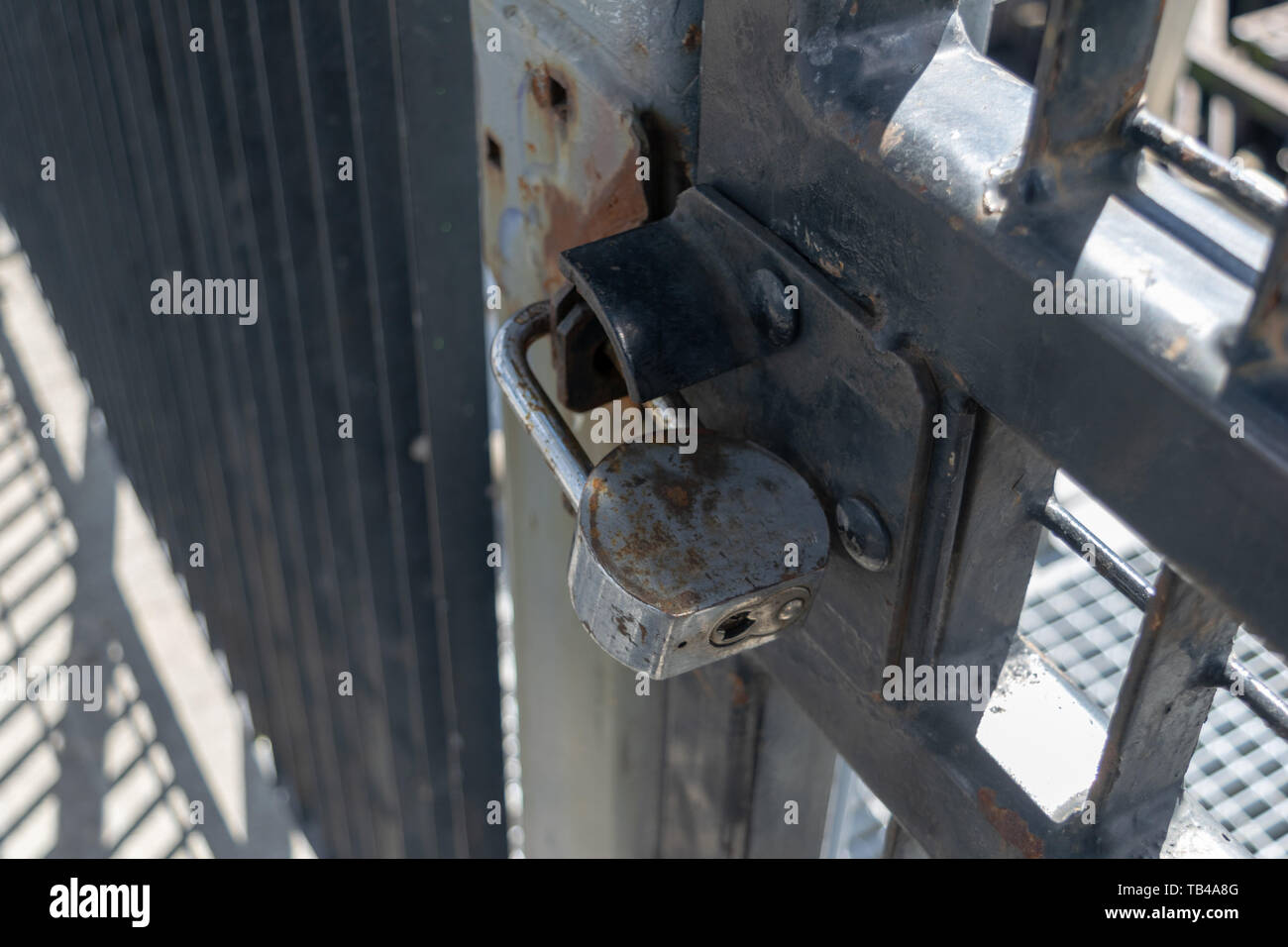 Old and rusty heavy duty pad lock securing aan iron gate, close-up ...