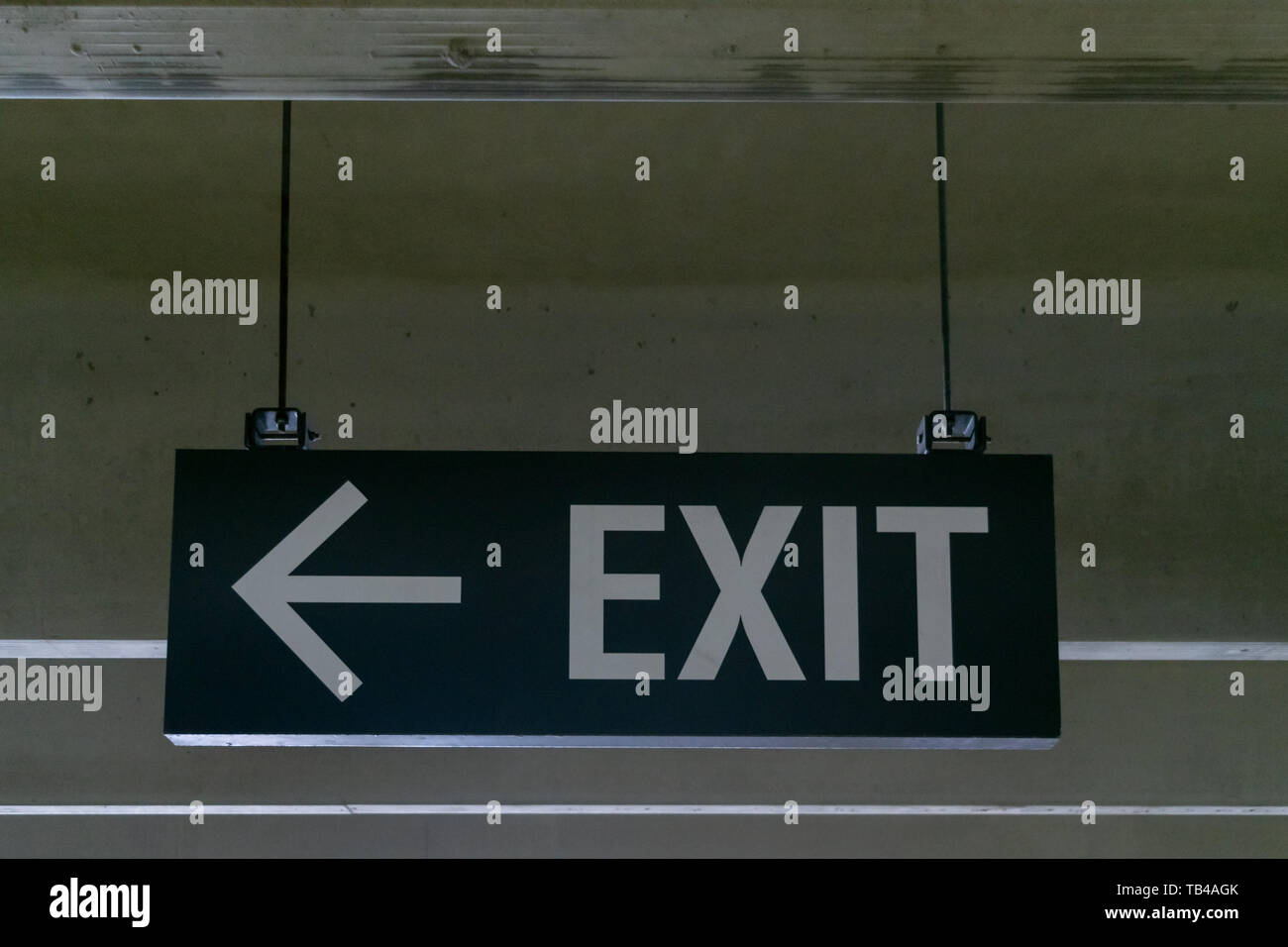 Mounted metal exit sign and arrow pointing to the left Stock Photo - Alamy