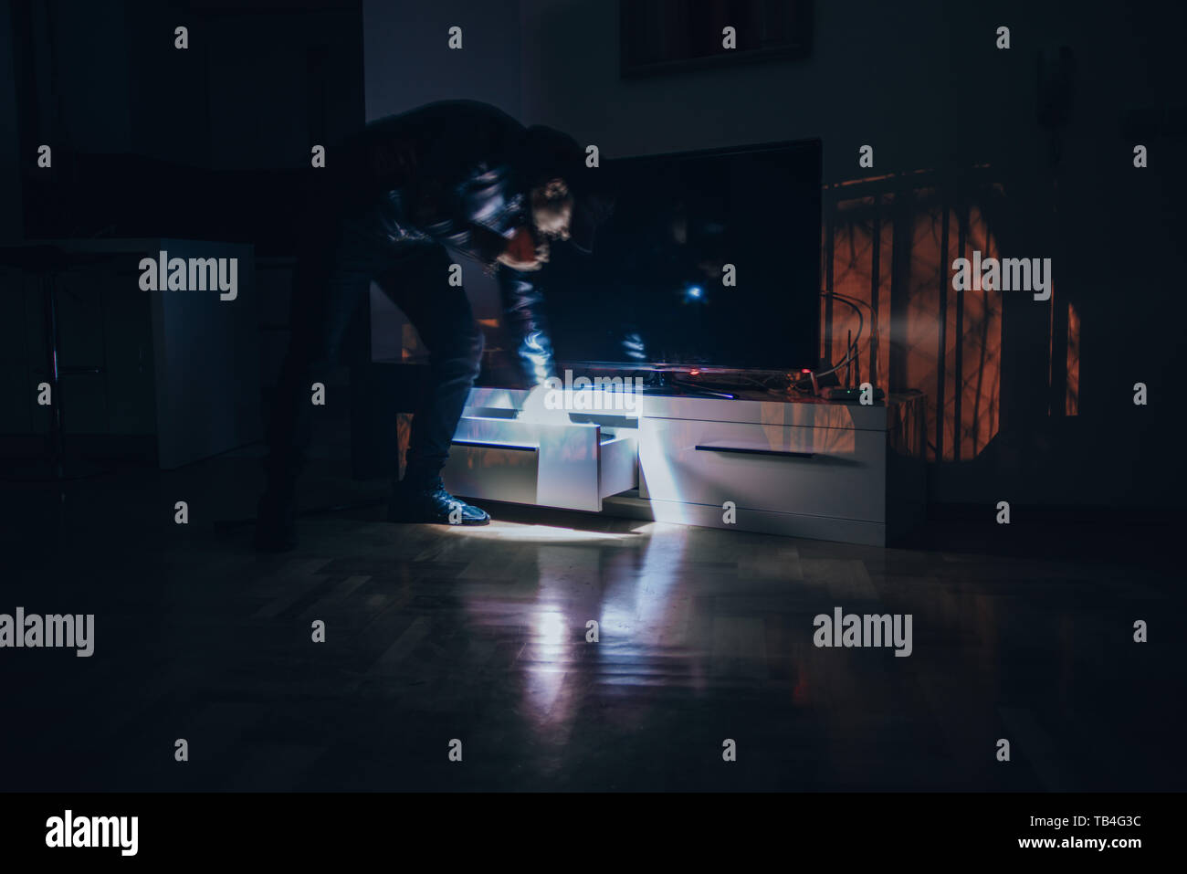 Robbery man in dark room stealing documents from desk Stock Photo - Alamy