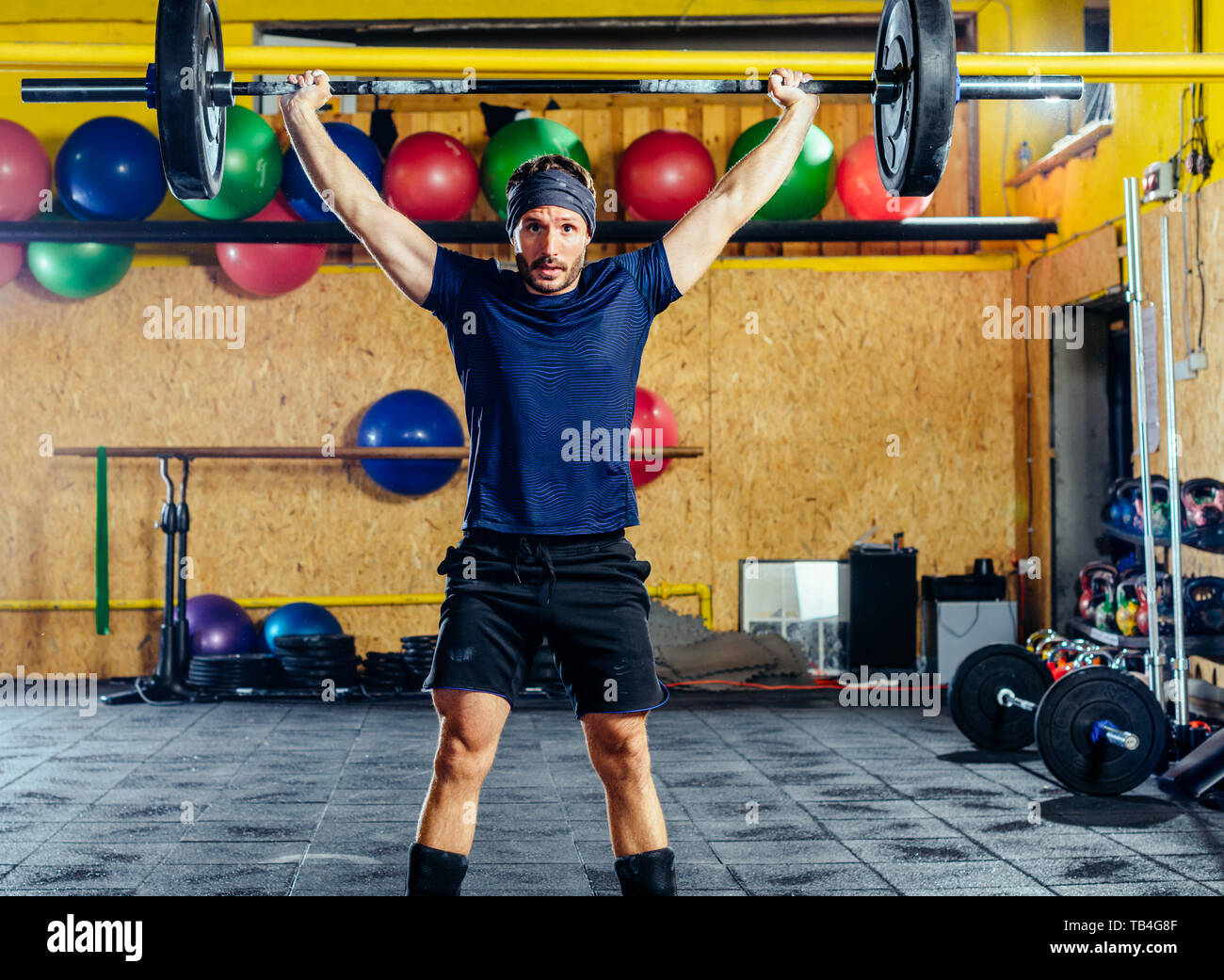 Fitness man is raising barbell in the gym Stock Photo - Alamy