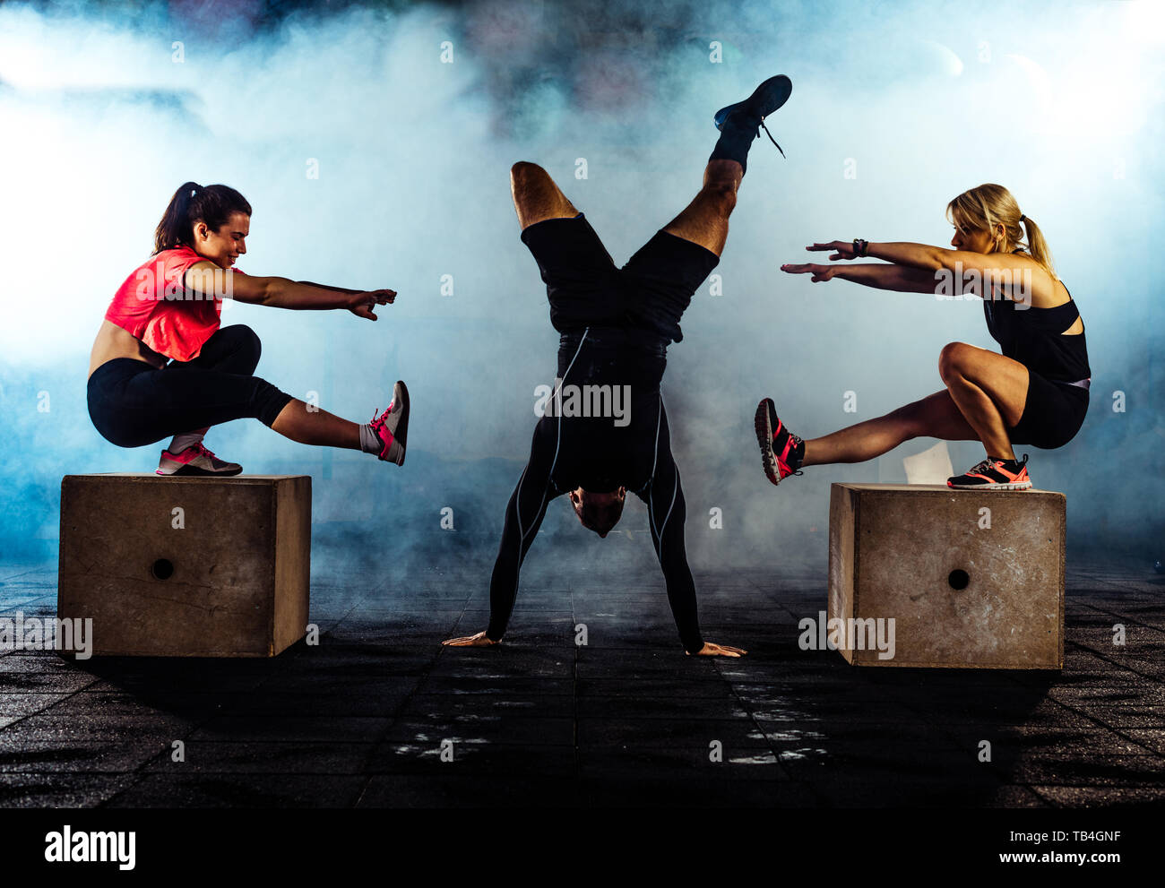 Crossfit class jumping on wooden boxes guided by trainer Stock Photo ...