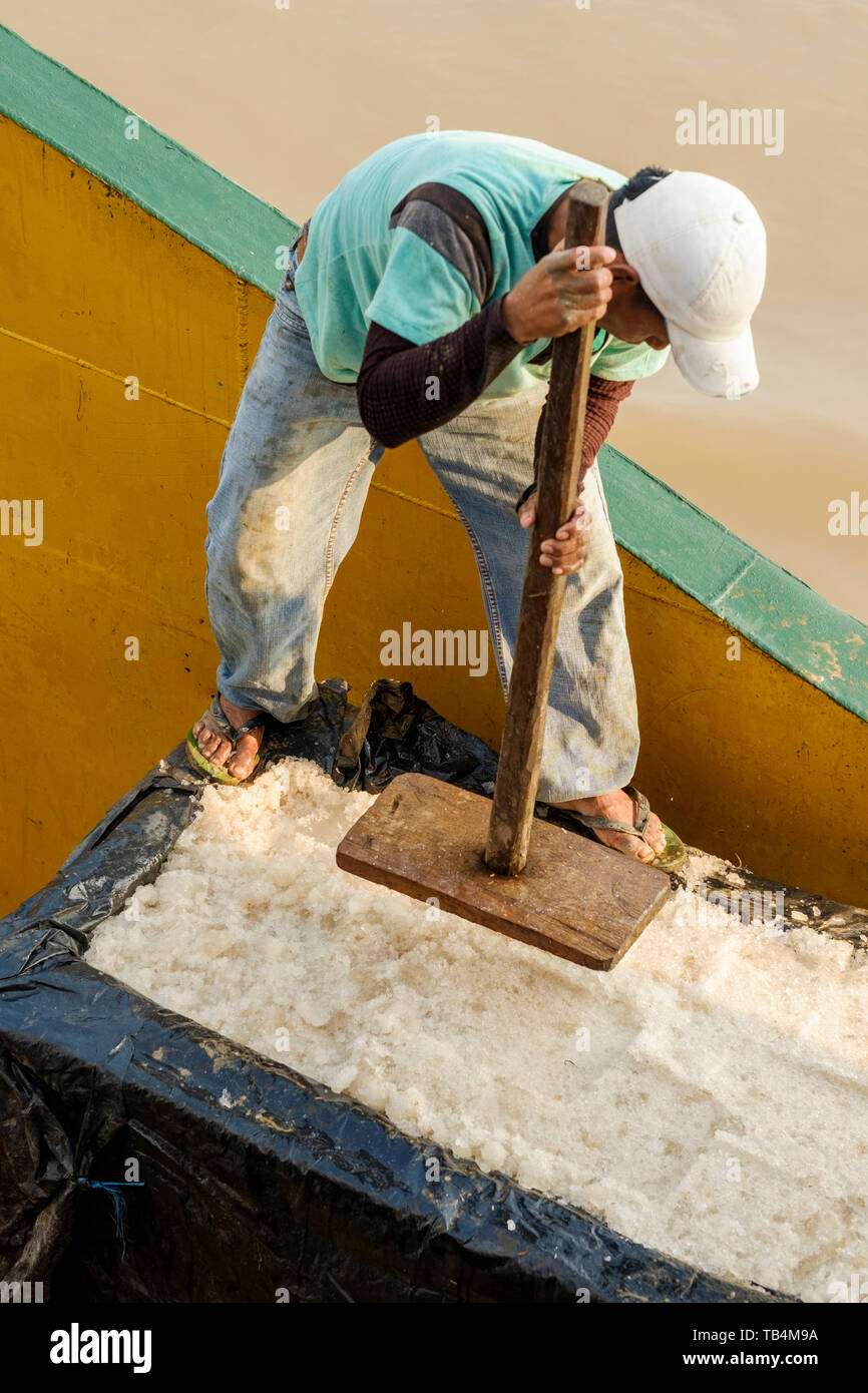 Local fisherman fixing the ice for his fish cargo at ferry Iquitos ...