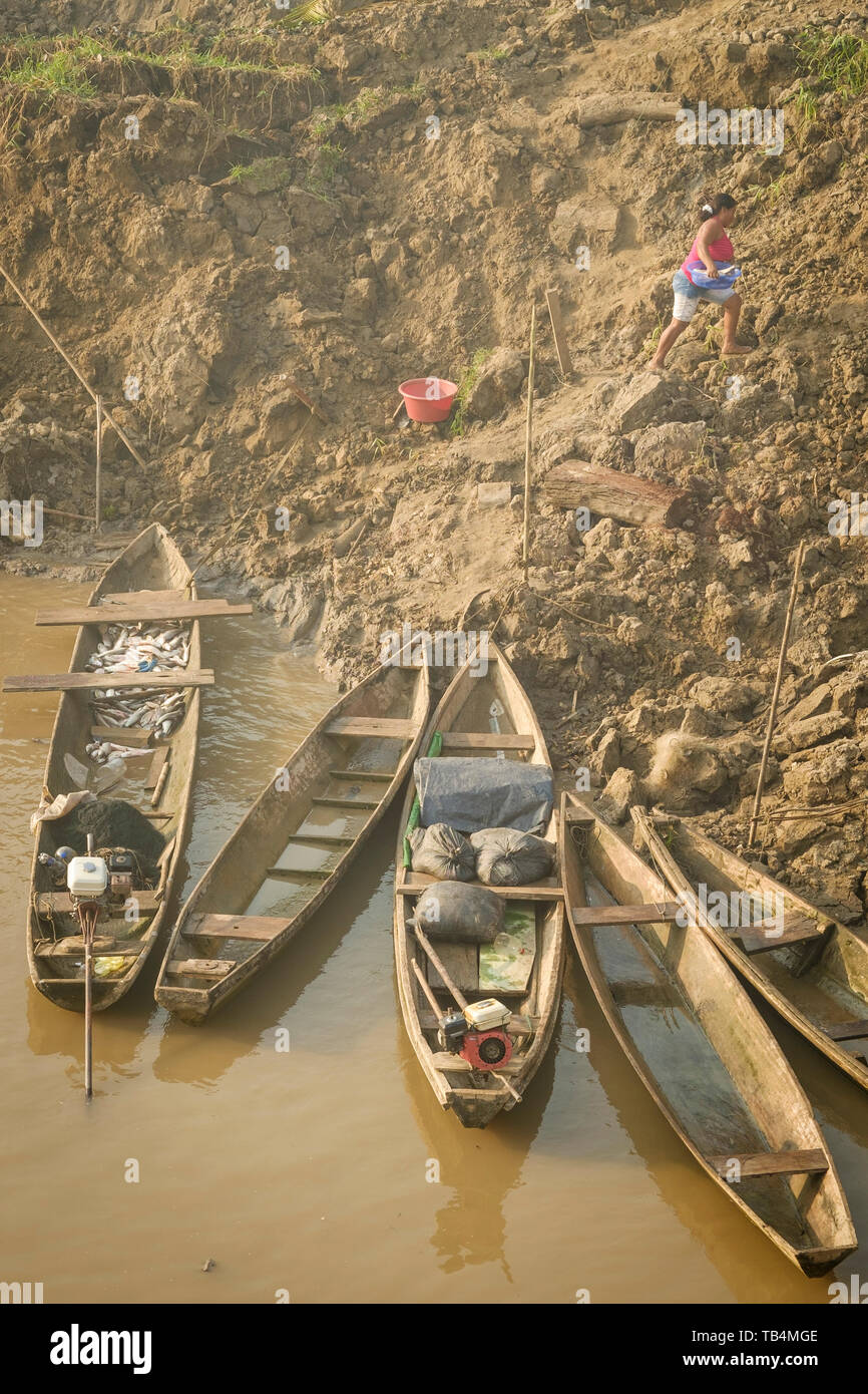 Woman picking just cleaned fish from a wooden boat docked on the ...
