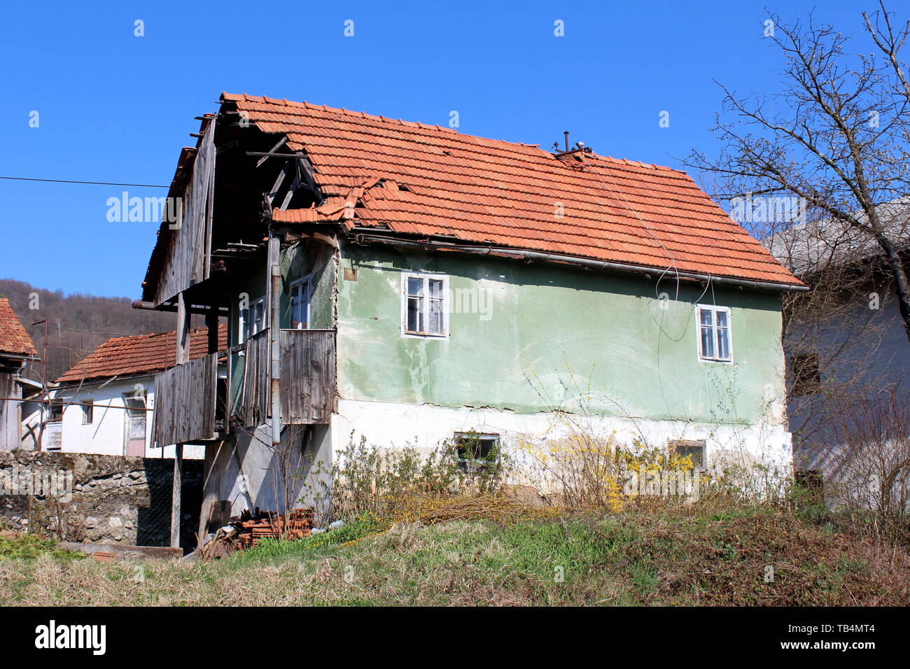 Abandoned old family house with broken roof tiles and cracked front ...