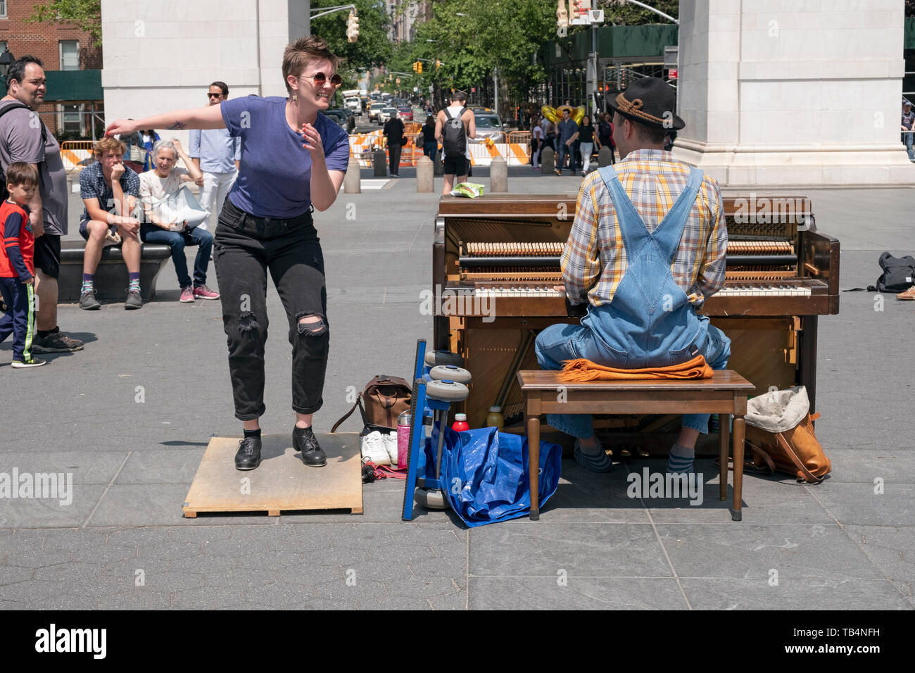 A pretty tap dancer and a piano player perform together near the arch ...