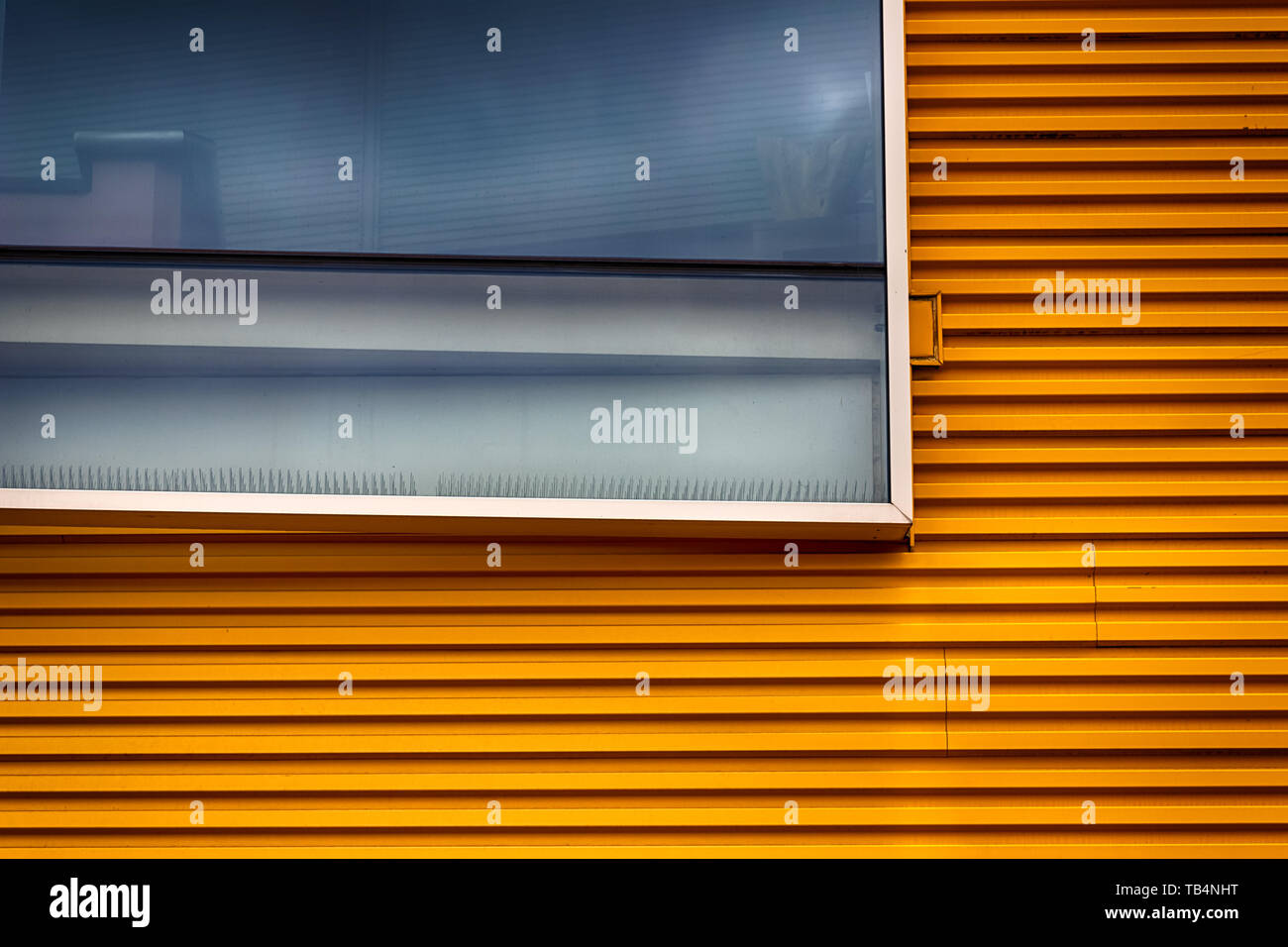 Abstract yellow modern building exterior with glass window in daylight ...