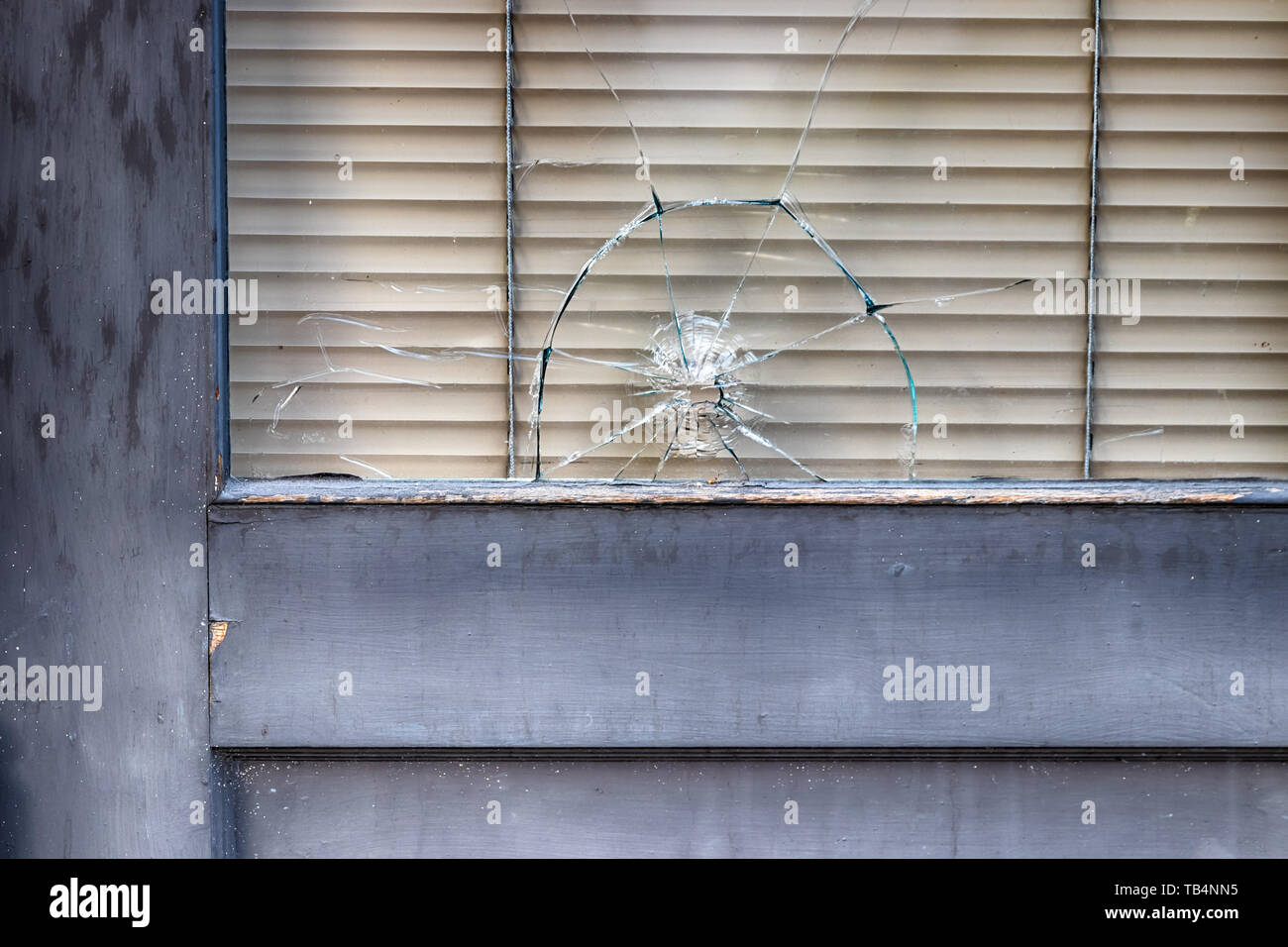 Abstract old building storefront window with bullet hole in daylight ...