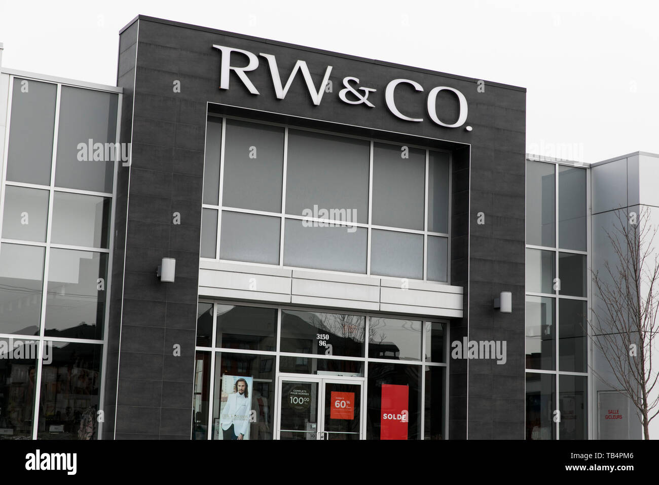 A logo sign outside of a RW&CO retail store location in Vaudreuil ...
