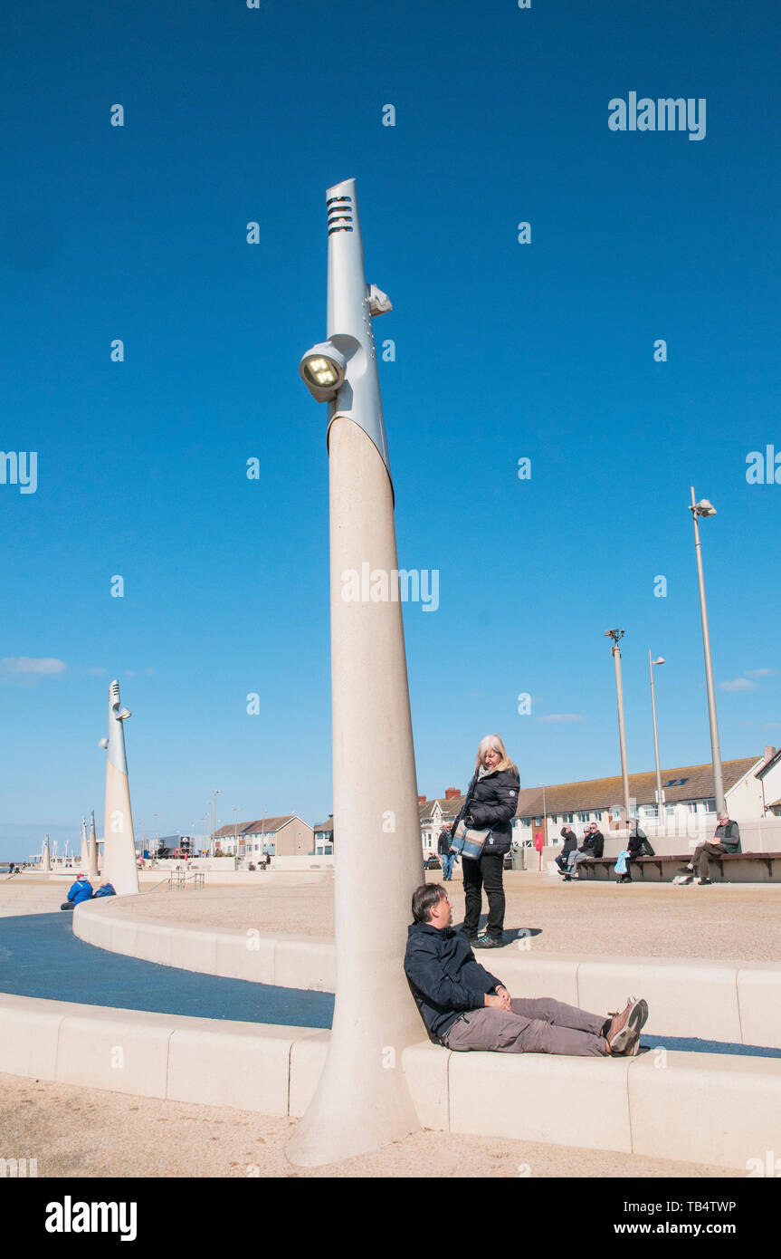 Man sitting on a wall and leaning against a futuristic style lighting ...