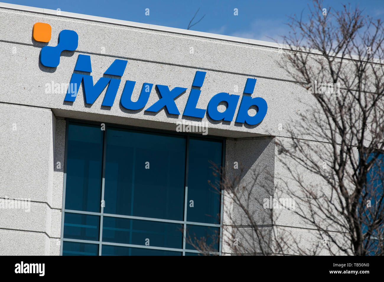 A logo sign outside of a facility occupied by Muxlab in Saint-Laurent ...