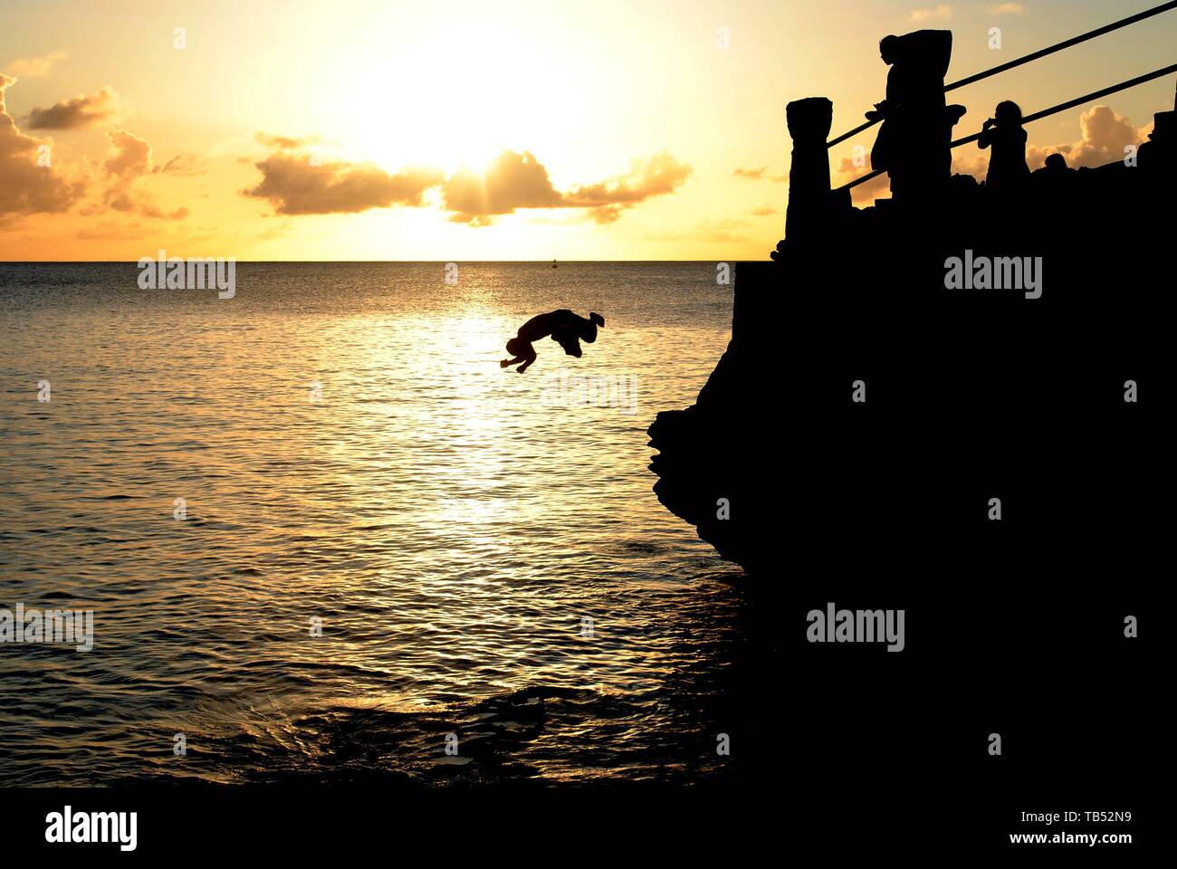 A man somersaults into the water from a ledge at the Taga beach, Tinian ...