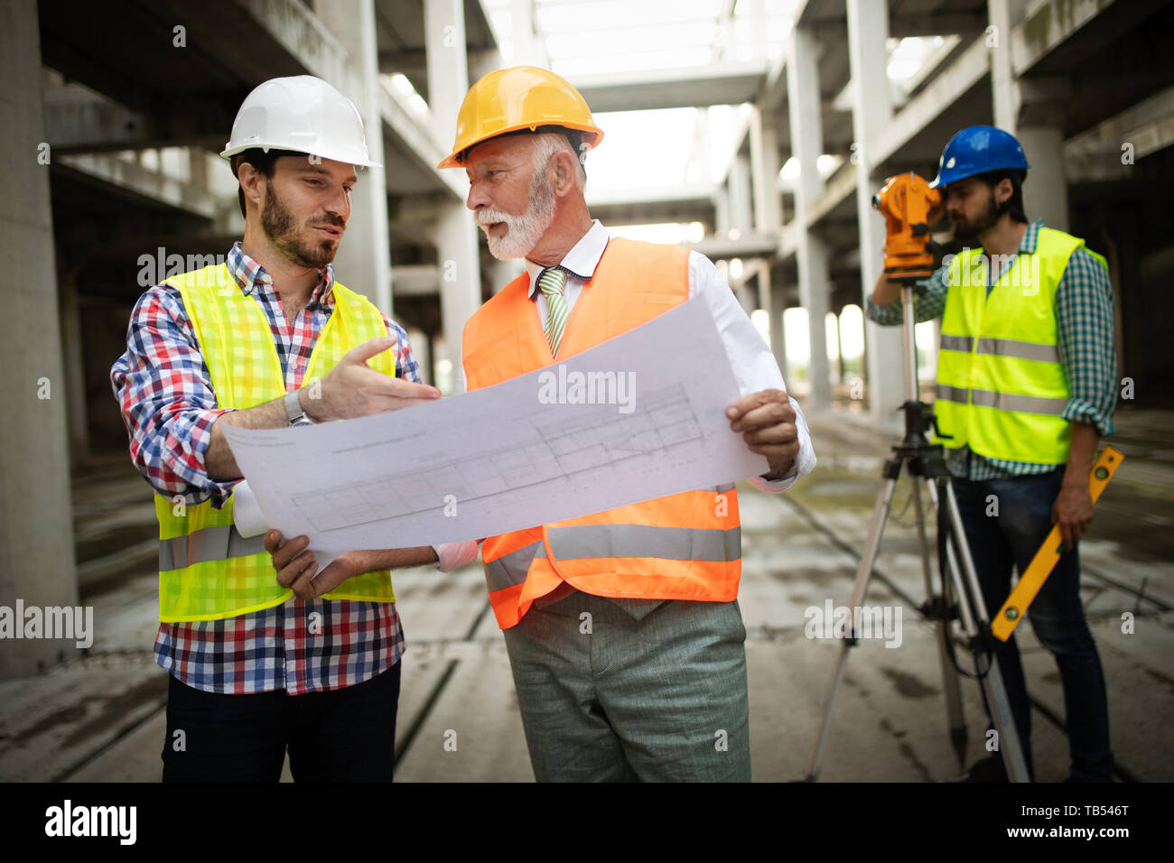 Engineer and construction site manager dealing with blueprints and ...