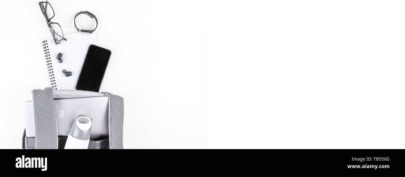 Creative top view flat lay of open backpack with laptop and tablet ...