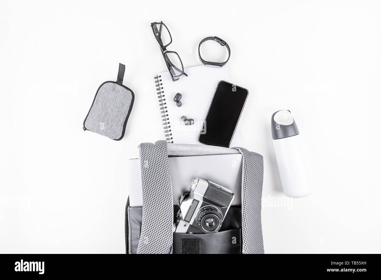 Creative top view flat lay of open backpack with laptop and tablet ...
