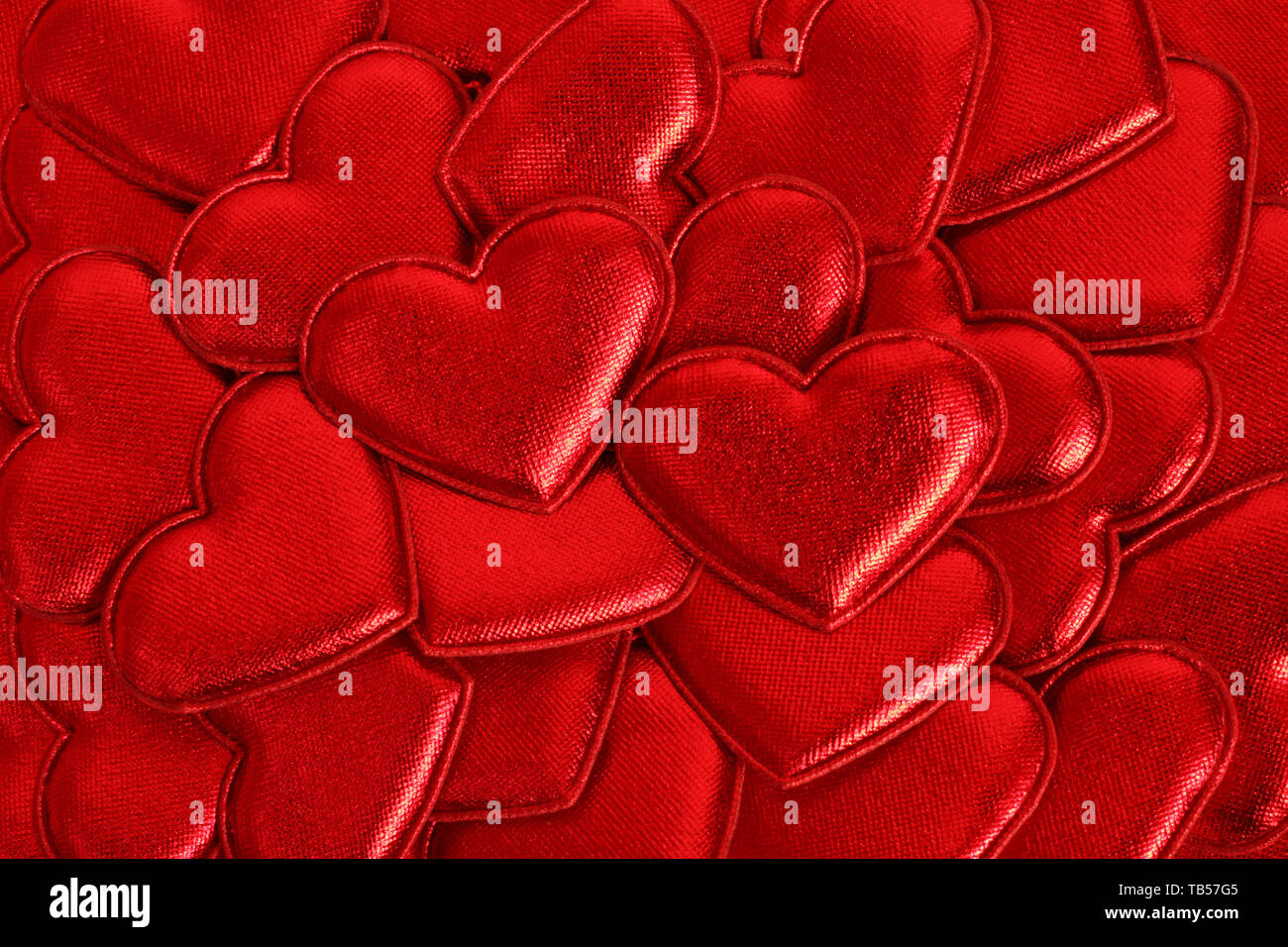 Red shiny fabric hearts arranged randomly. Background Stock Photo - Alamy