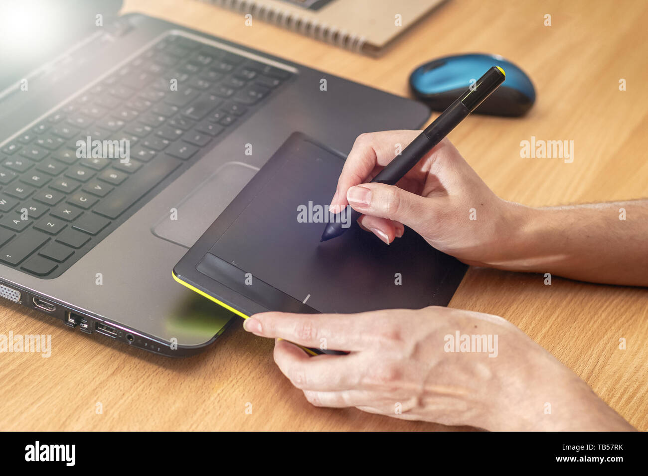 Illustrator using a graphics tablet. Woman's retoucher's hands using ...