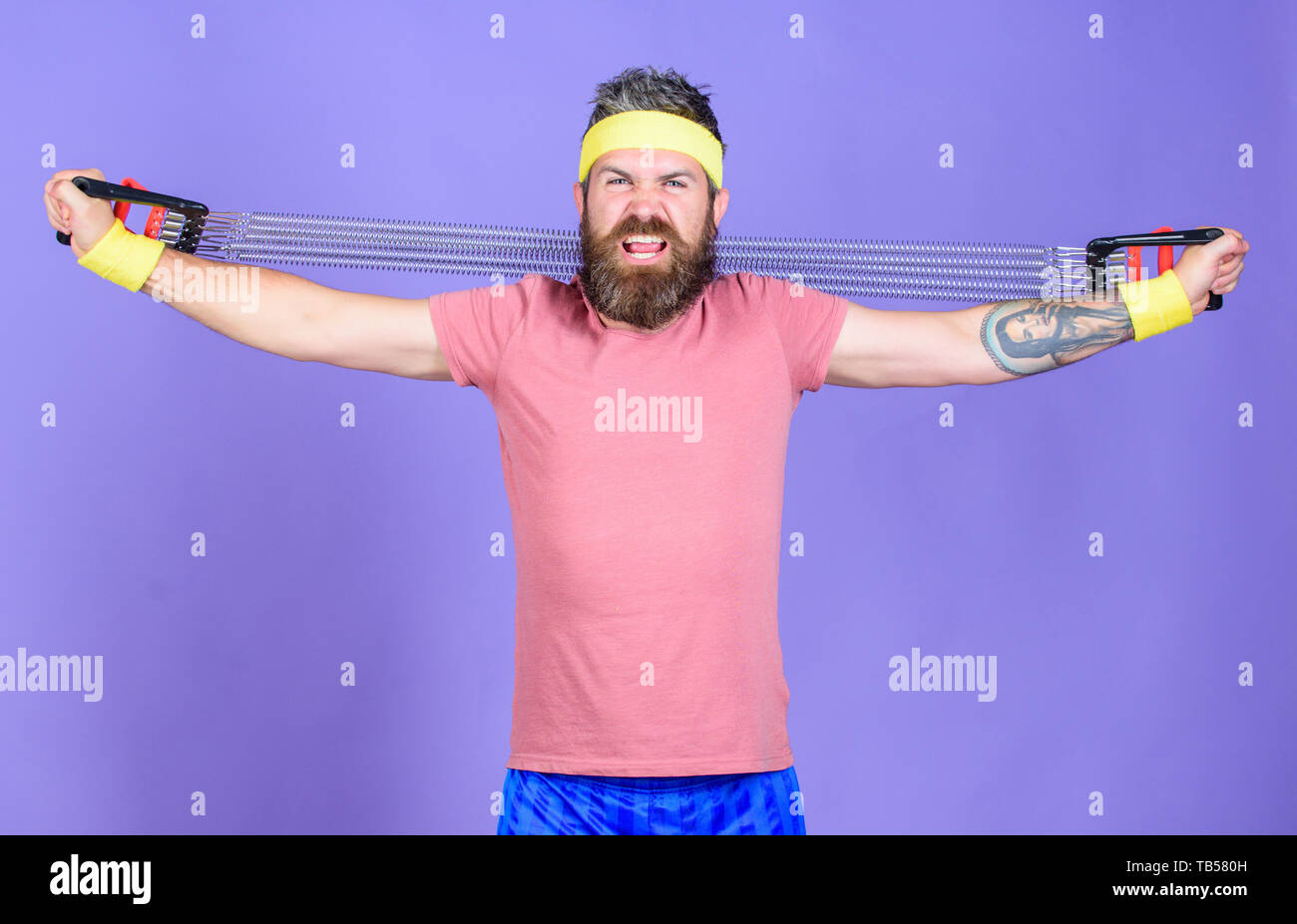 Lets stretch arms. Athlete stretching with expander. Man bearded ...