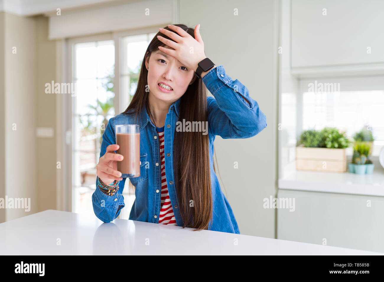 Beautiful Asian woman drinking a fresh glass of chocolate milkshake ...