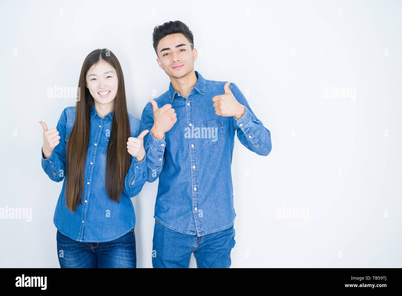 Beautiful young asian couple over white isolated background success ...
