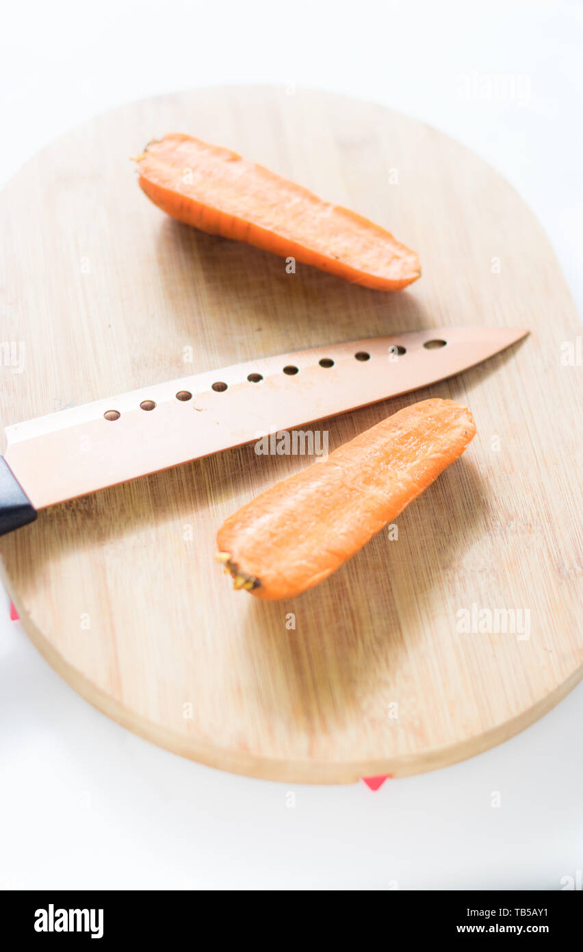 half carrot with knife white background Stock Photo - Alamy