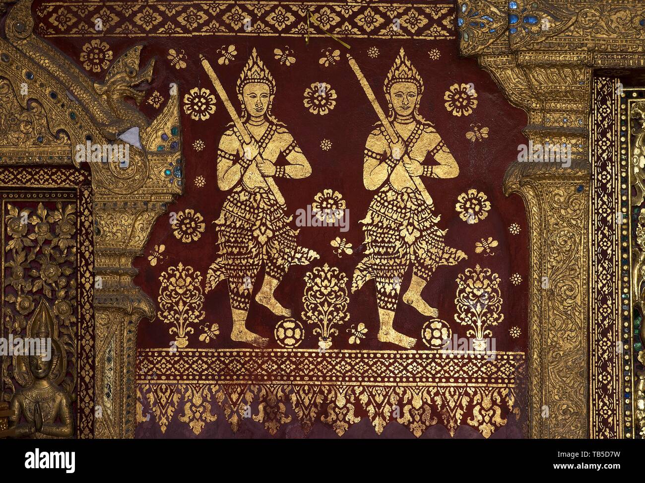 Temple guard, gilded figures on red background at the temple entrance ...