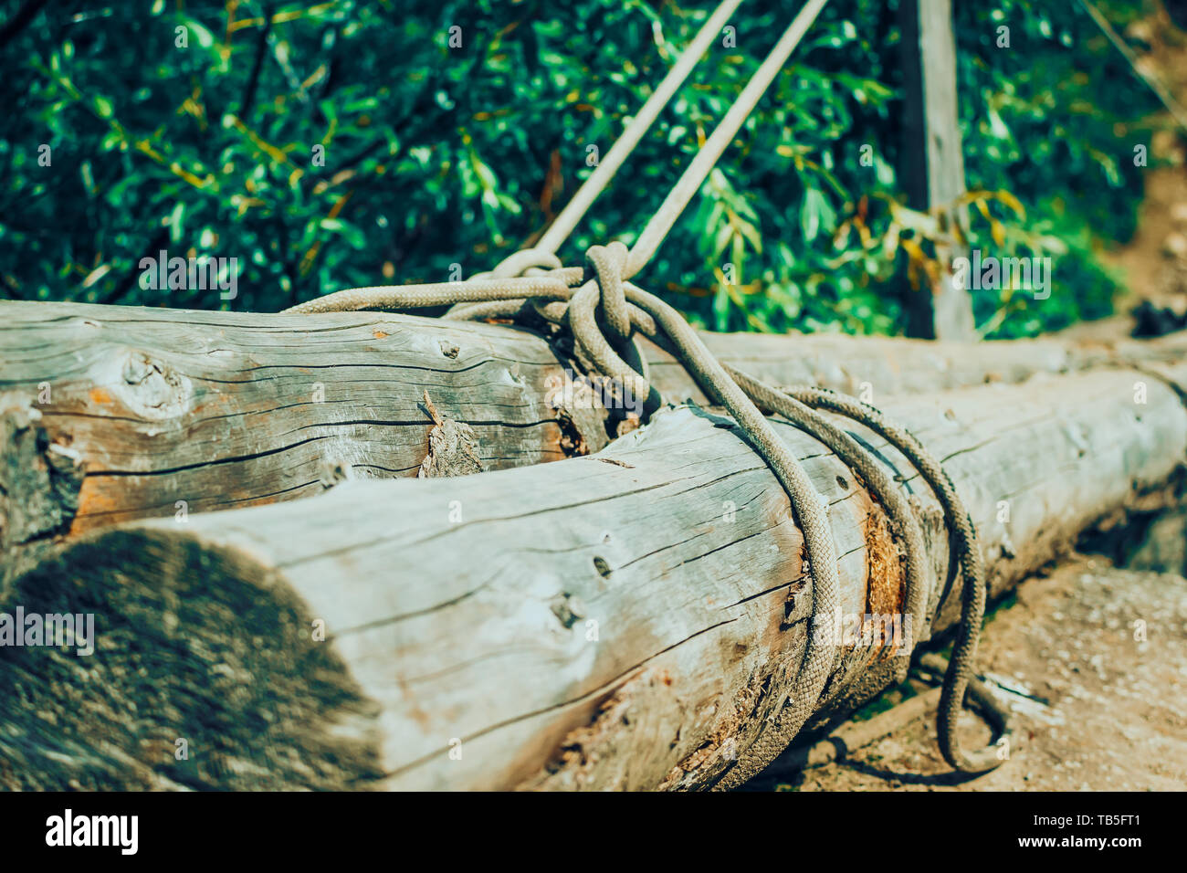 Old wooden tourist bridge made of woods and ropes across mountain river ...