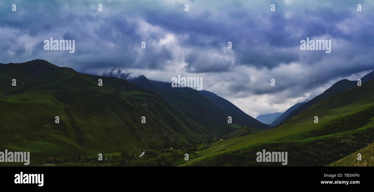 Valley with dramatic dark clouds and rain, storm clouds over the valley ...