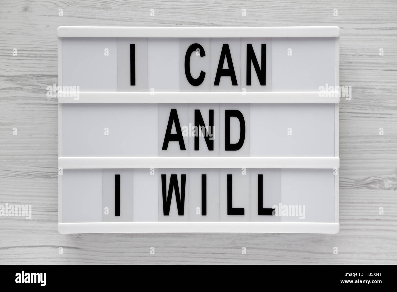 'I can and I will' words on a lightbox on a white wooden surface, top ...
