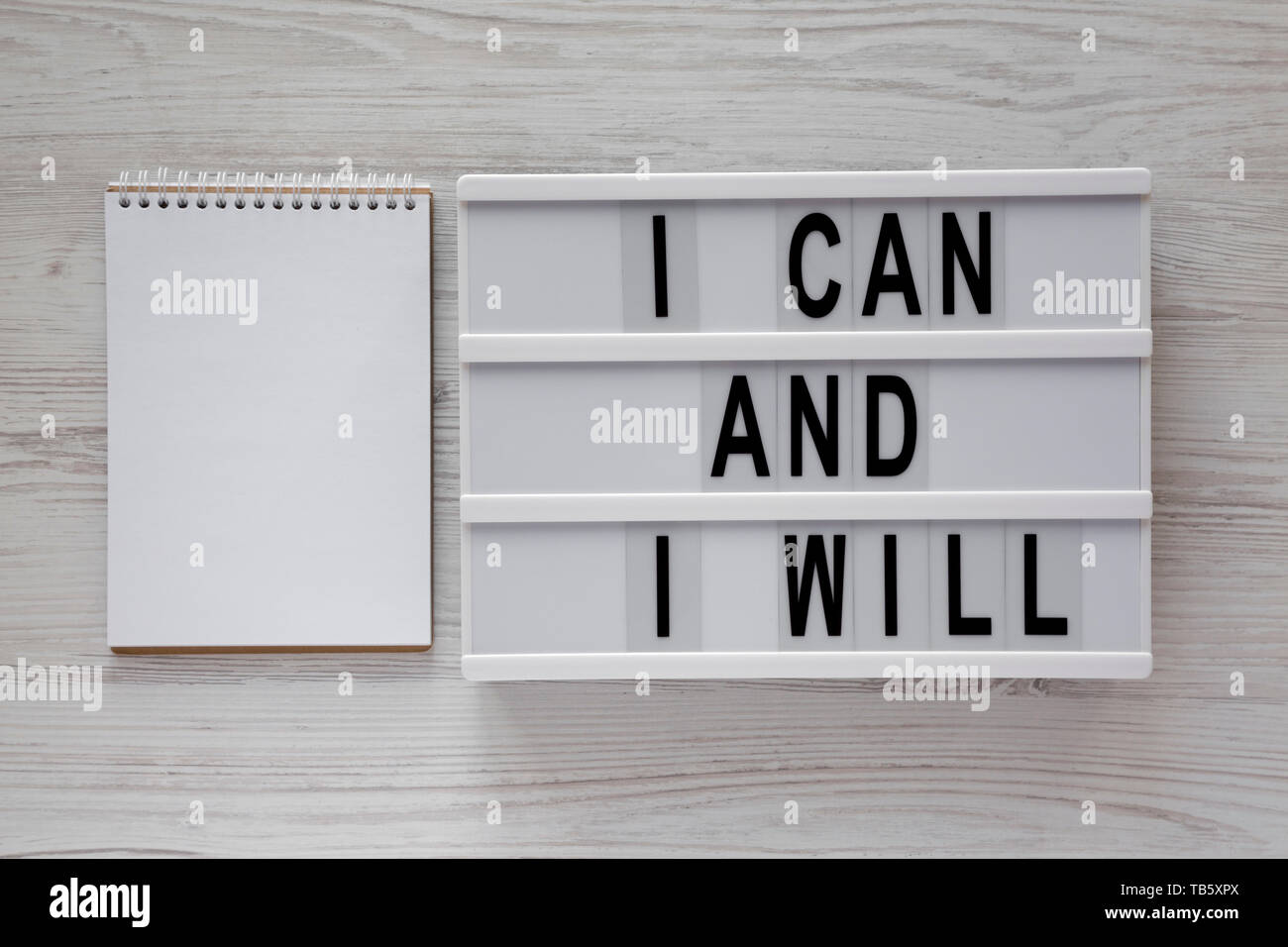 'I can and I will' words on a modern board, blank notepad over white ...