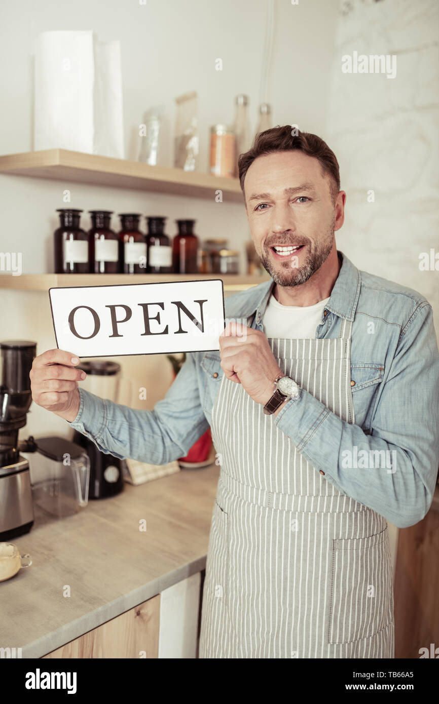 Just opened. Handsome happy man standing in the kitchen of his own ...