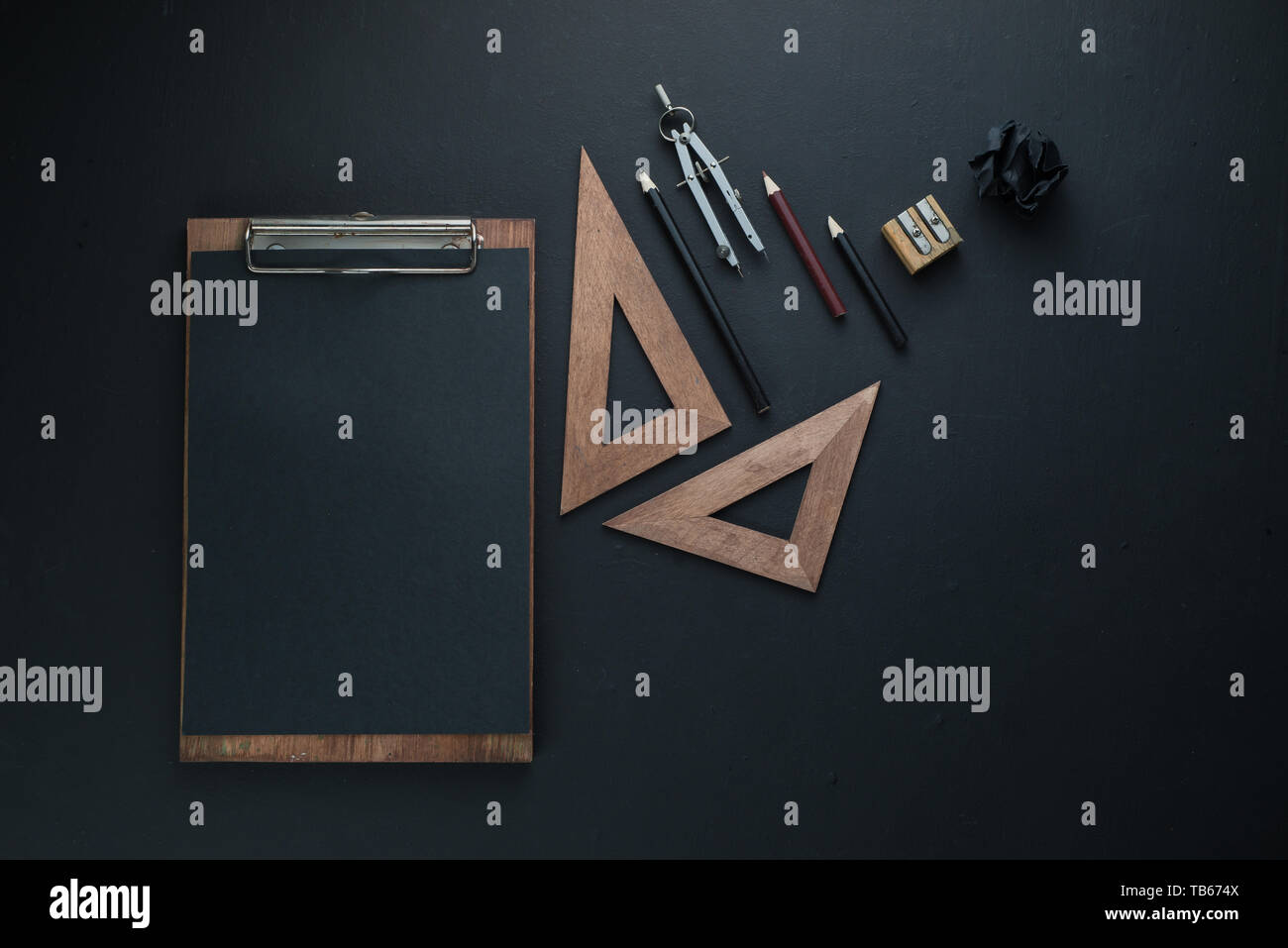 Black on black flat lay with a clipboard, pencils, and rulers. Drawing ...