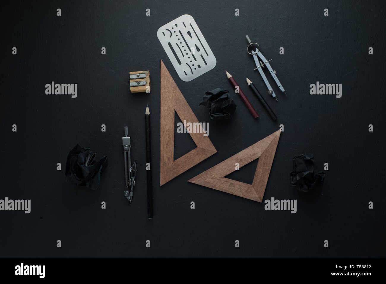 Drawing board flat lay with pencils, compasses, rulers and crumpled ...