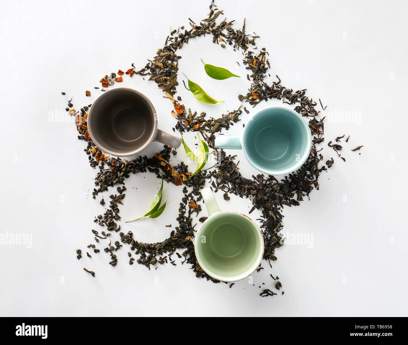 Composition with empty cups and different types of dry tea leaves on ...