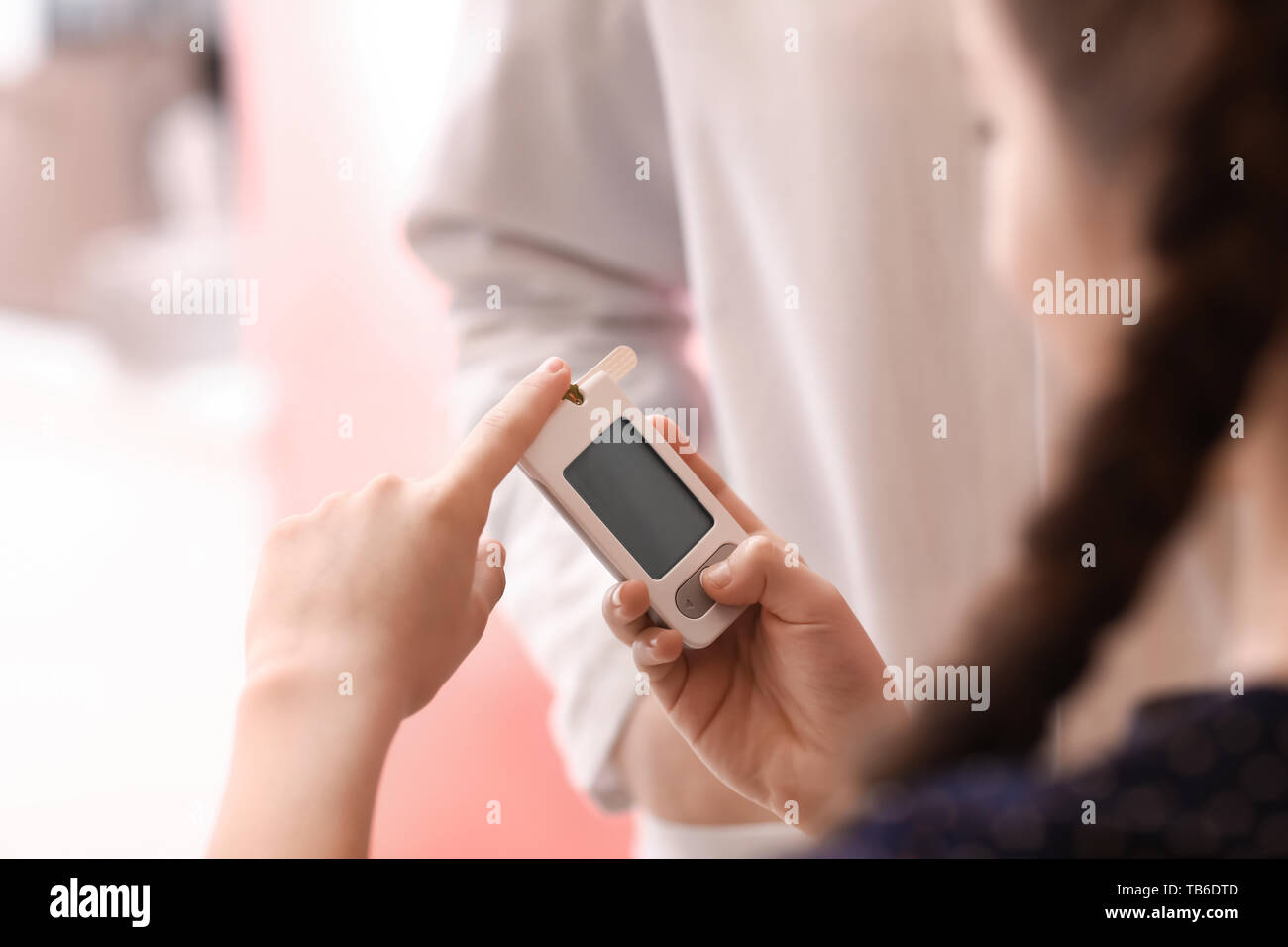 Diabetic girl with digital glucometer in clinic Stock Photo - Alamy